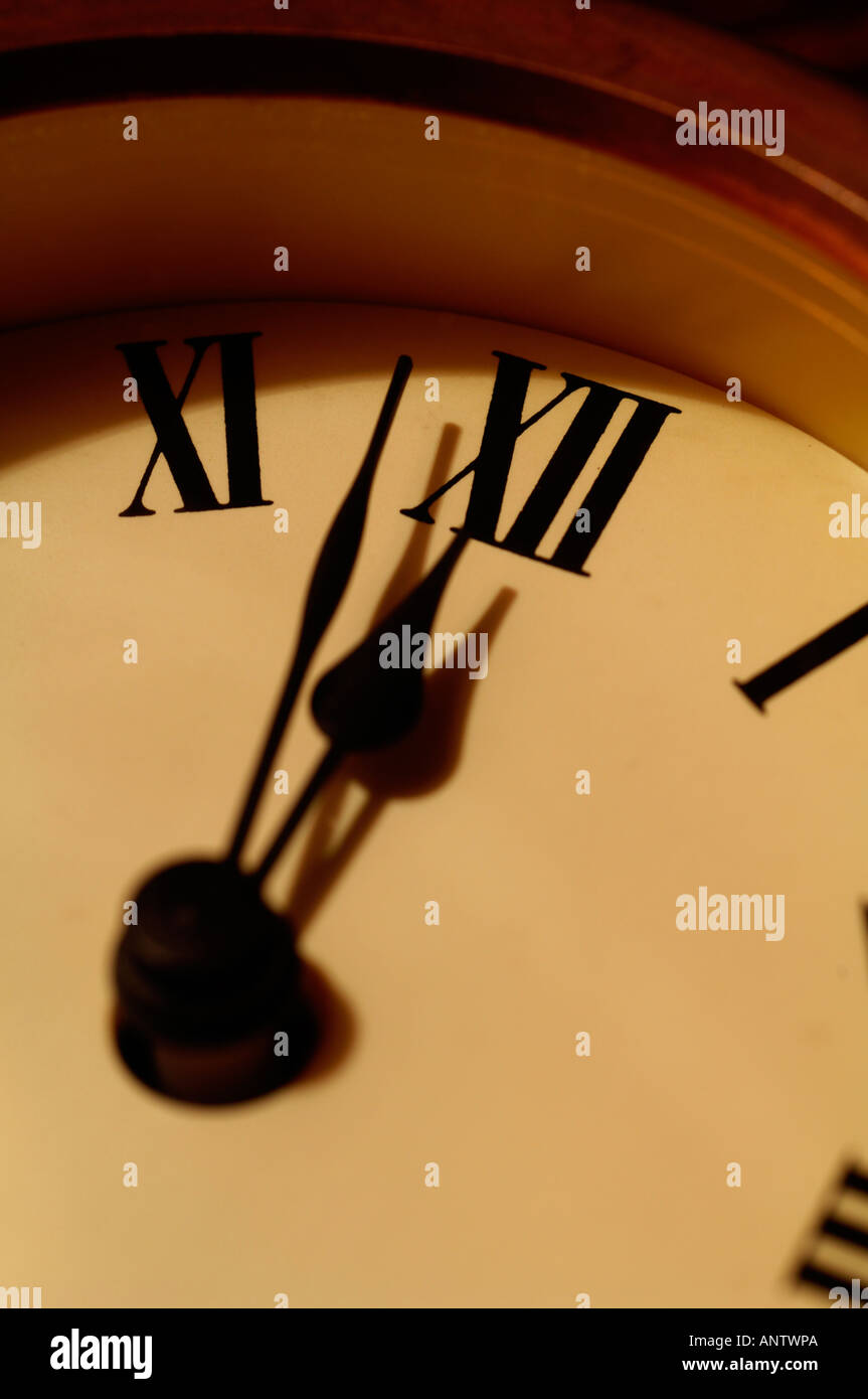 Close up of old fashioned clock face with hands at nearly twelve o ...