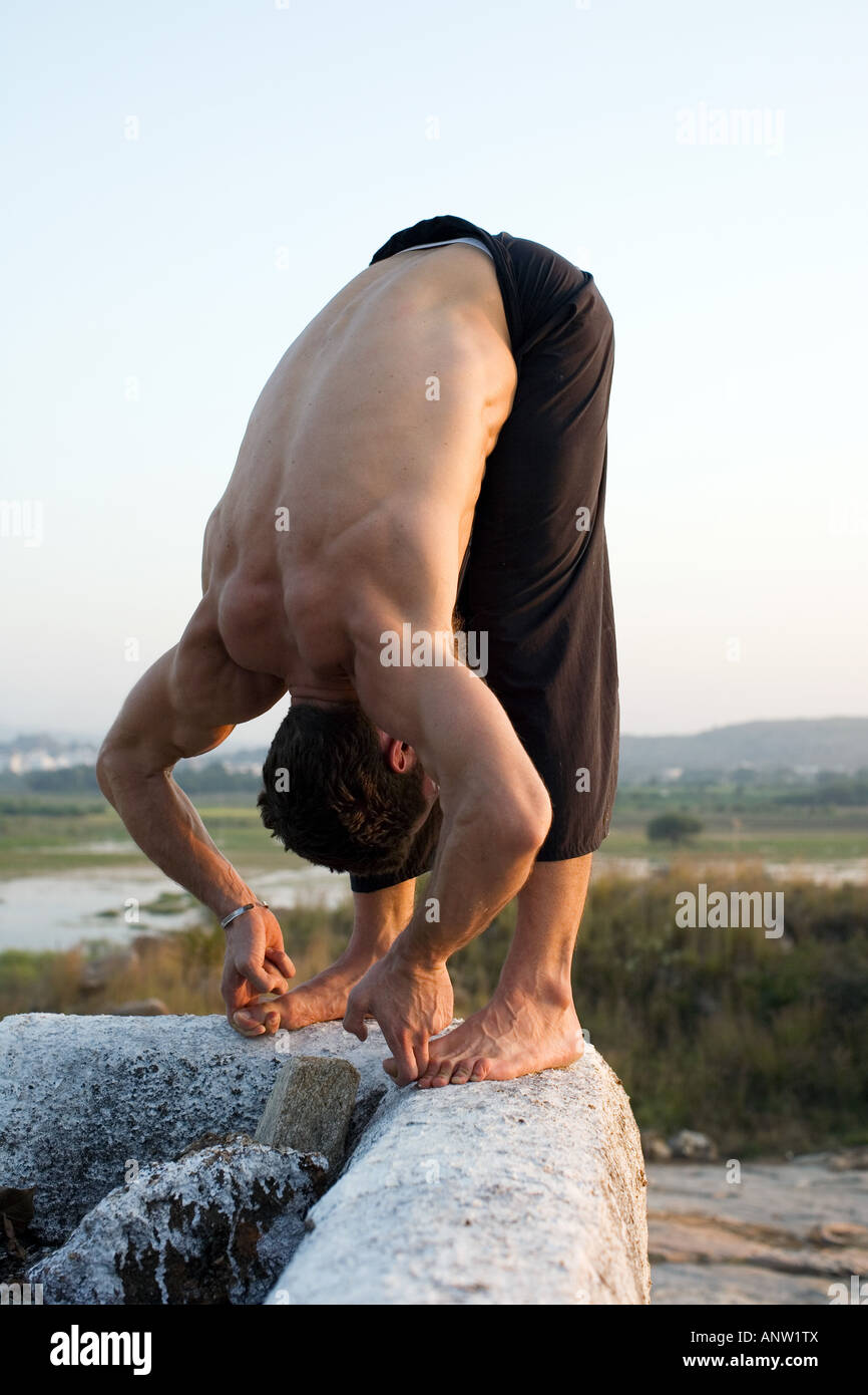 Man performing Hatha Yoga, Uttanasana, standing forward bend on a hindu ...