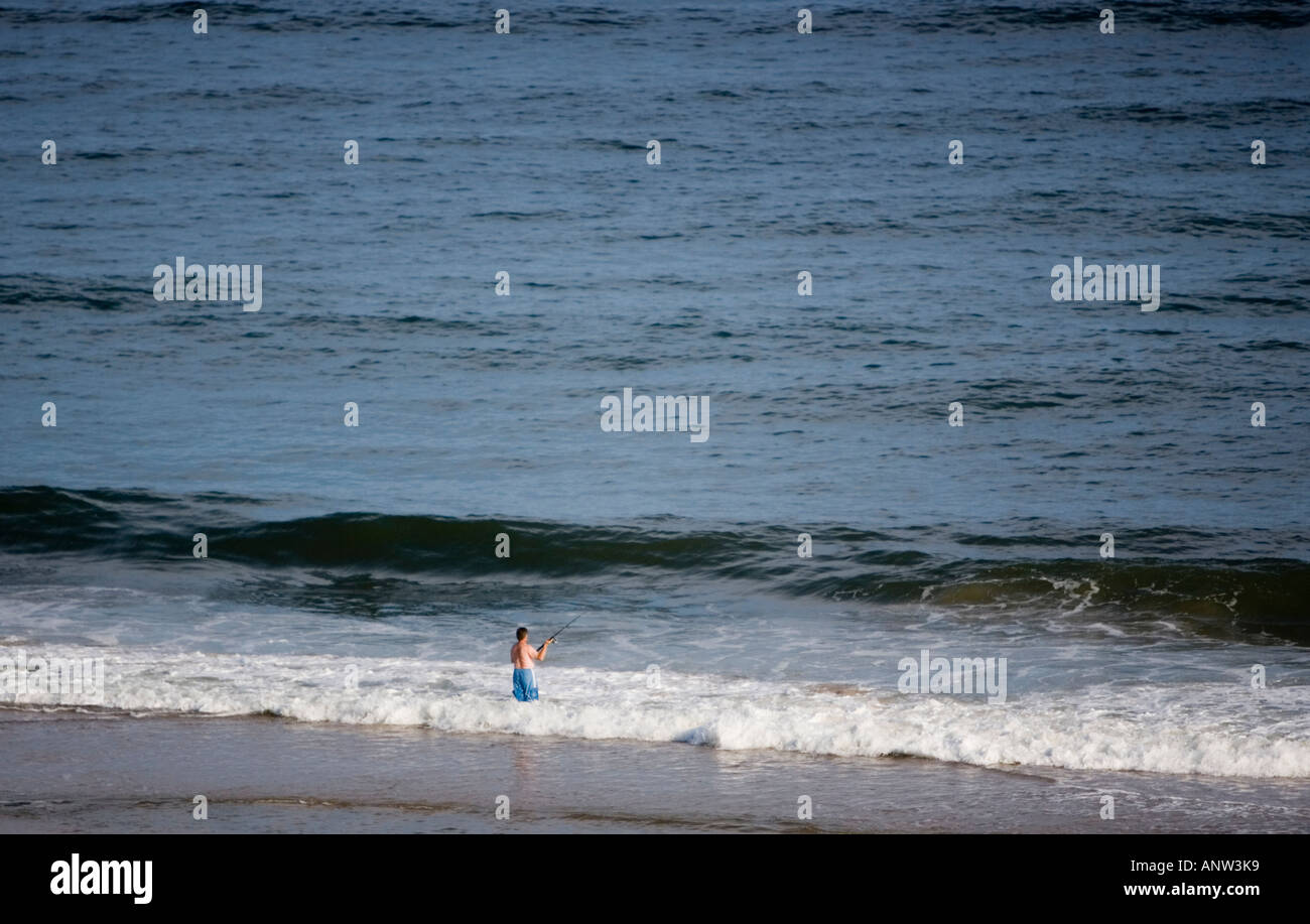 Man surf casting on the beach Stock Photo - Alamy