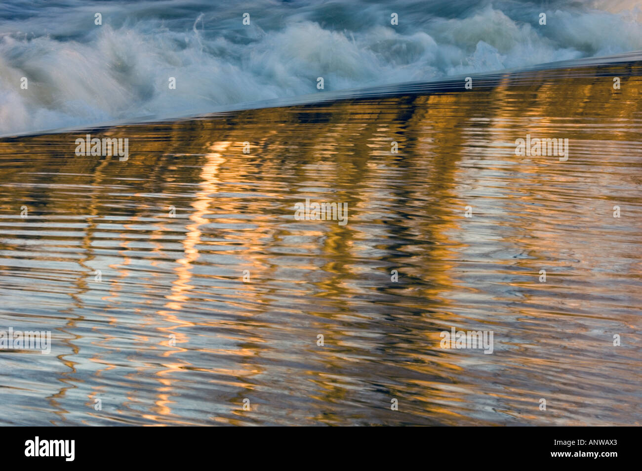 Distorted tree reflections in open water of Junction Creek flowing over ...