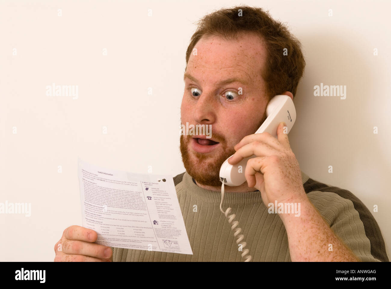 man on phone questioning items on his bank statements showing startled ...