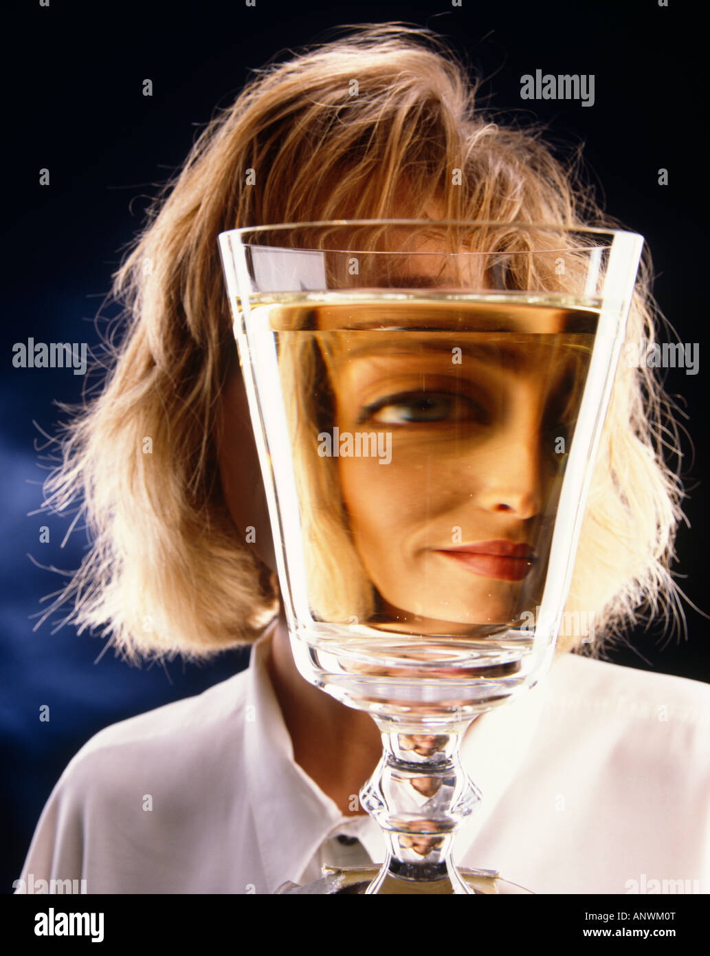 Young woman looking through alcoholic drink Stock Photo - Alamy