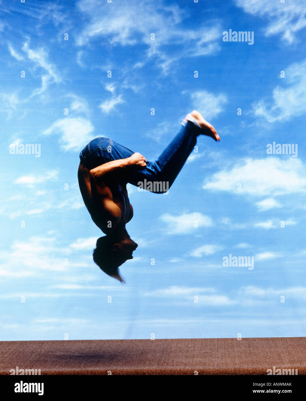 Guy doing a somersault against sky background Stock Photo - Alamy