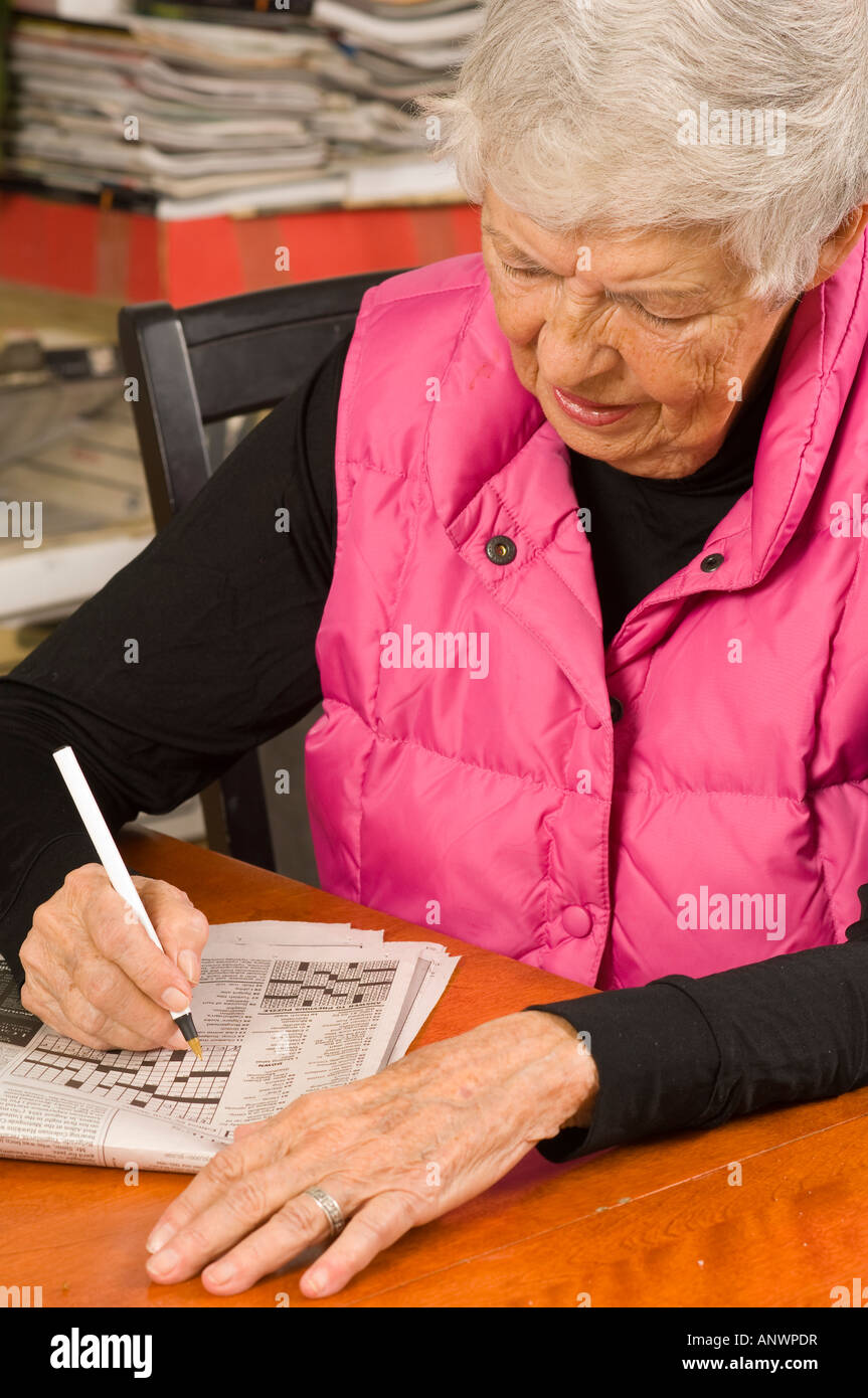 Senior woman working on crossword puzzle in newspaper vertical Stock ...
