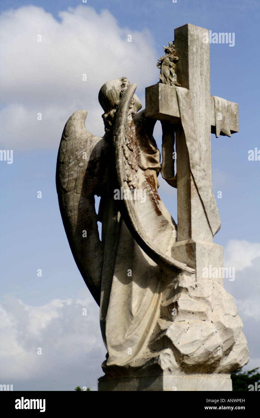 angel hanging on to a cross Stock Photo - Alamy