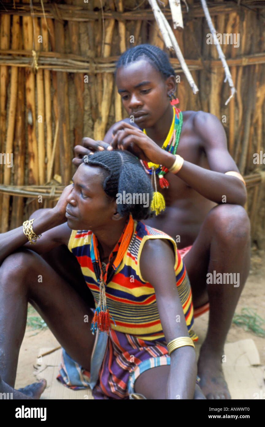 Two Hamar men working on their hair in a Hamar tribe, in the Omo river ...