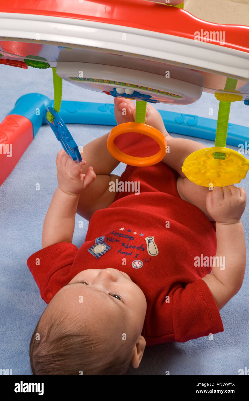 3 month old baby boy on back closeup reaching to touch or grasp hanging ...