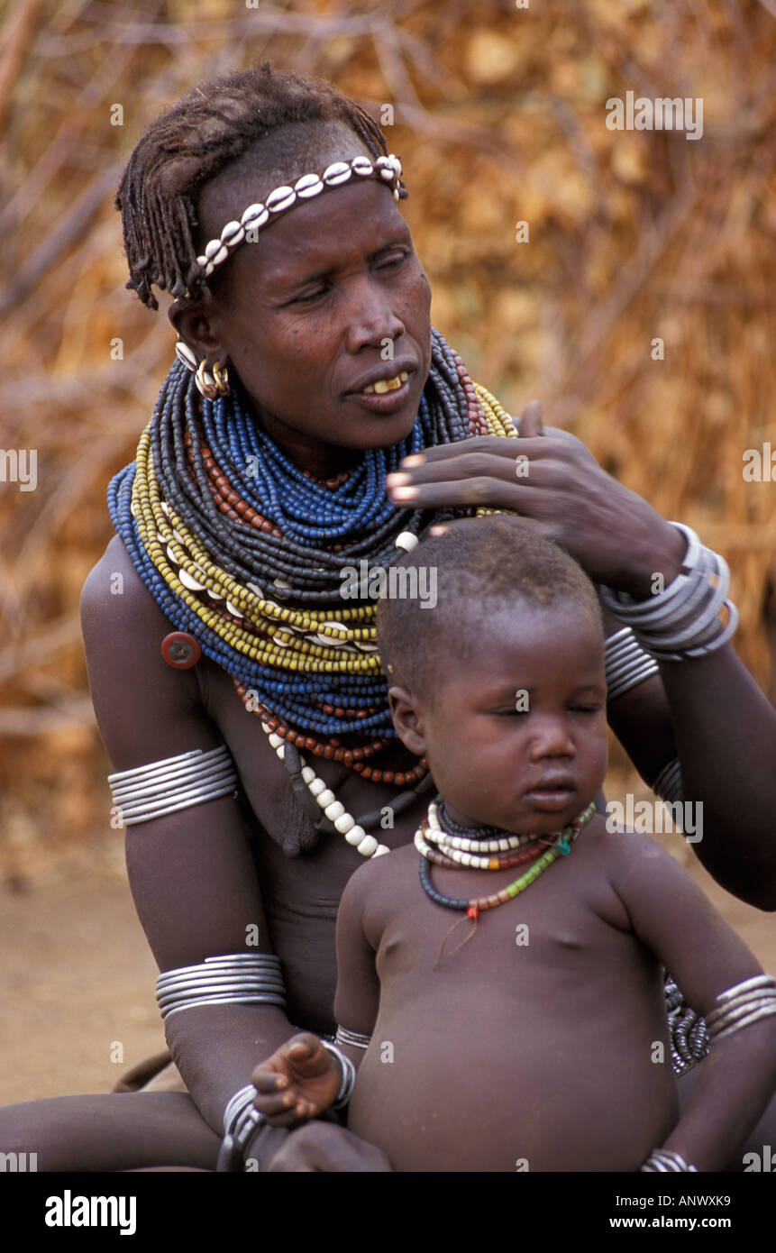 A Bume woman and her child sit together, in their village, in Ethiopia ...