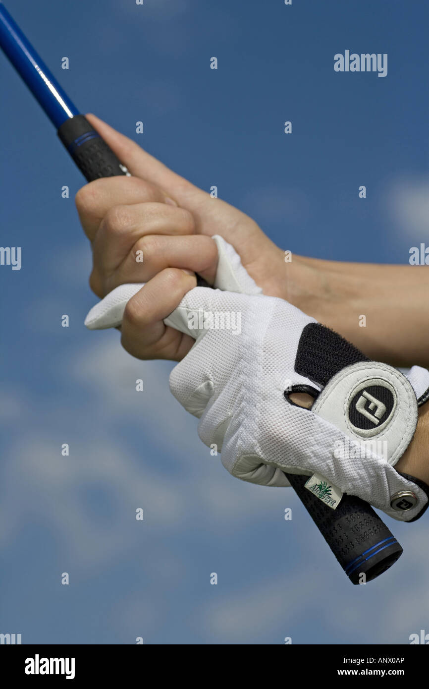 two hands one with a glove holding a golf club Stock Photo - Alamy