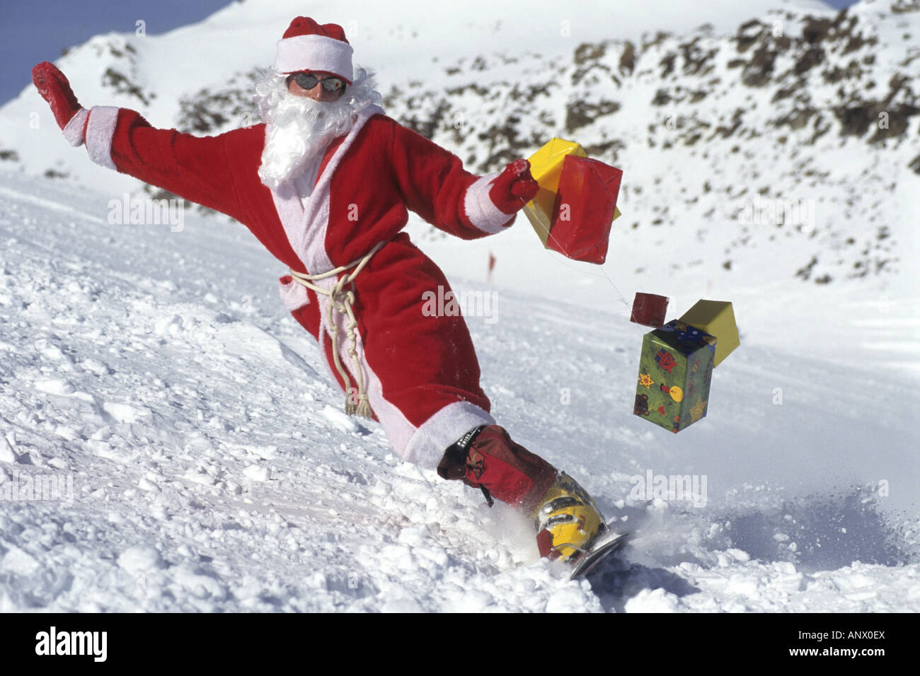 Santa Claus with Christmas presents on a snowboard, Alps Stock Photo ...
