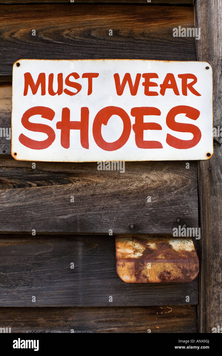 Must Wear Shoes sign hanging on wooden house Stock Photo - Alamy