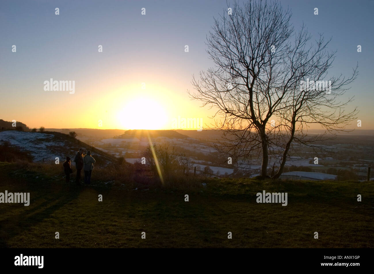 Winter scene with sun setting behind leafless trees overlooking Vale of ...