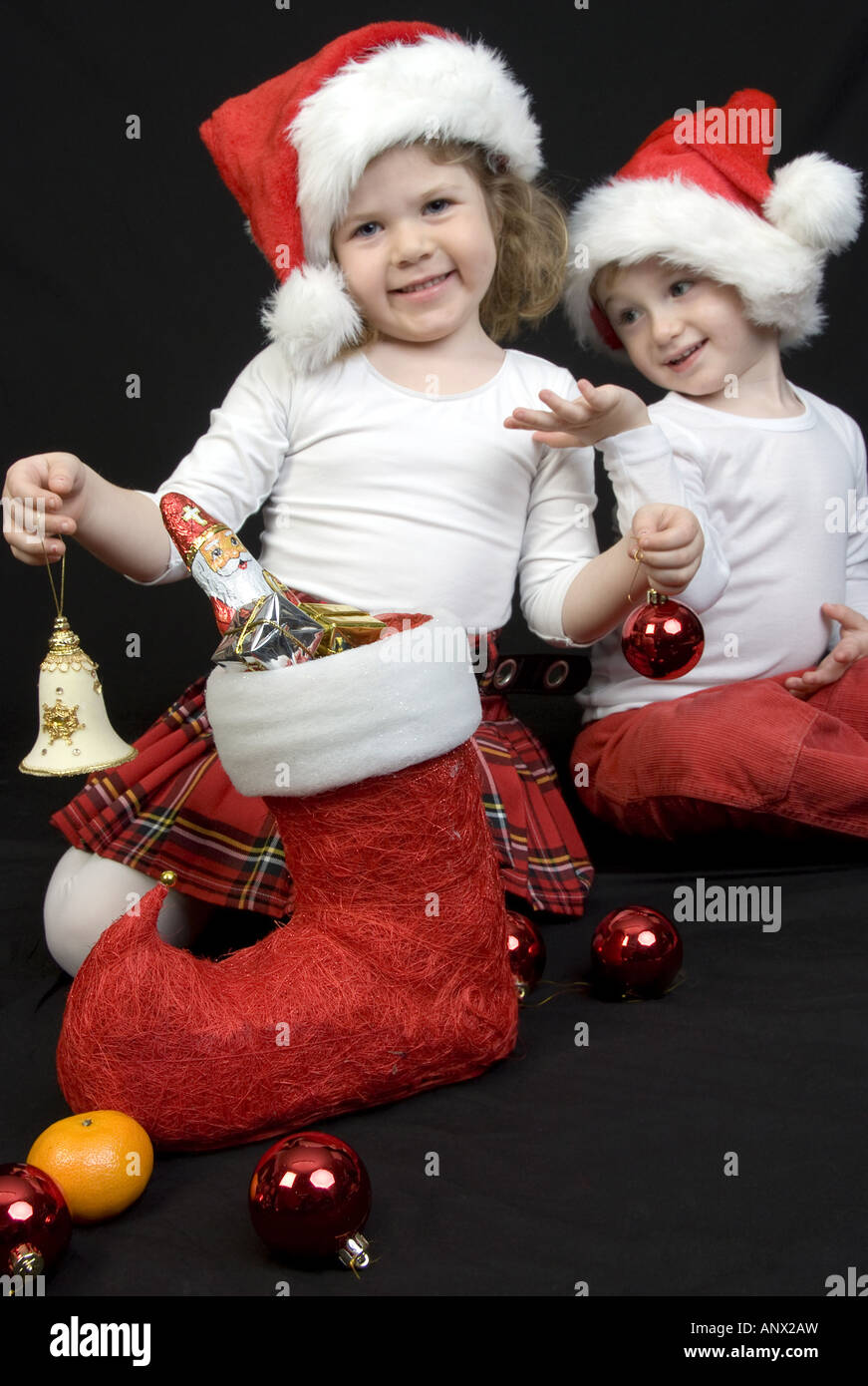 christmas kids with christmas stocking in front of black background ...