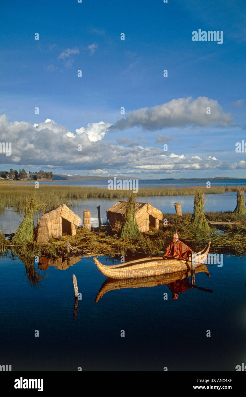 man of uros tribe riding totora reed boat at evening floating island ...