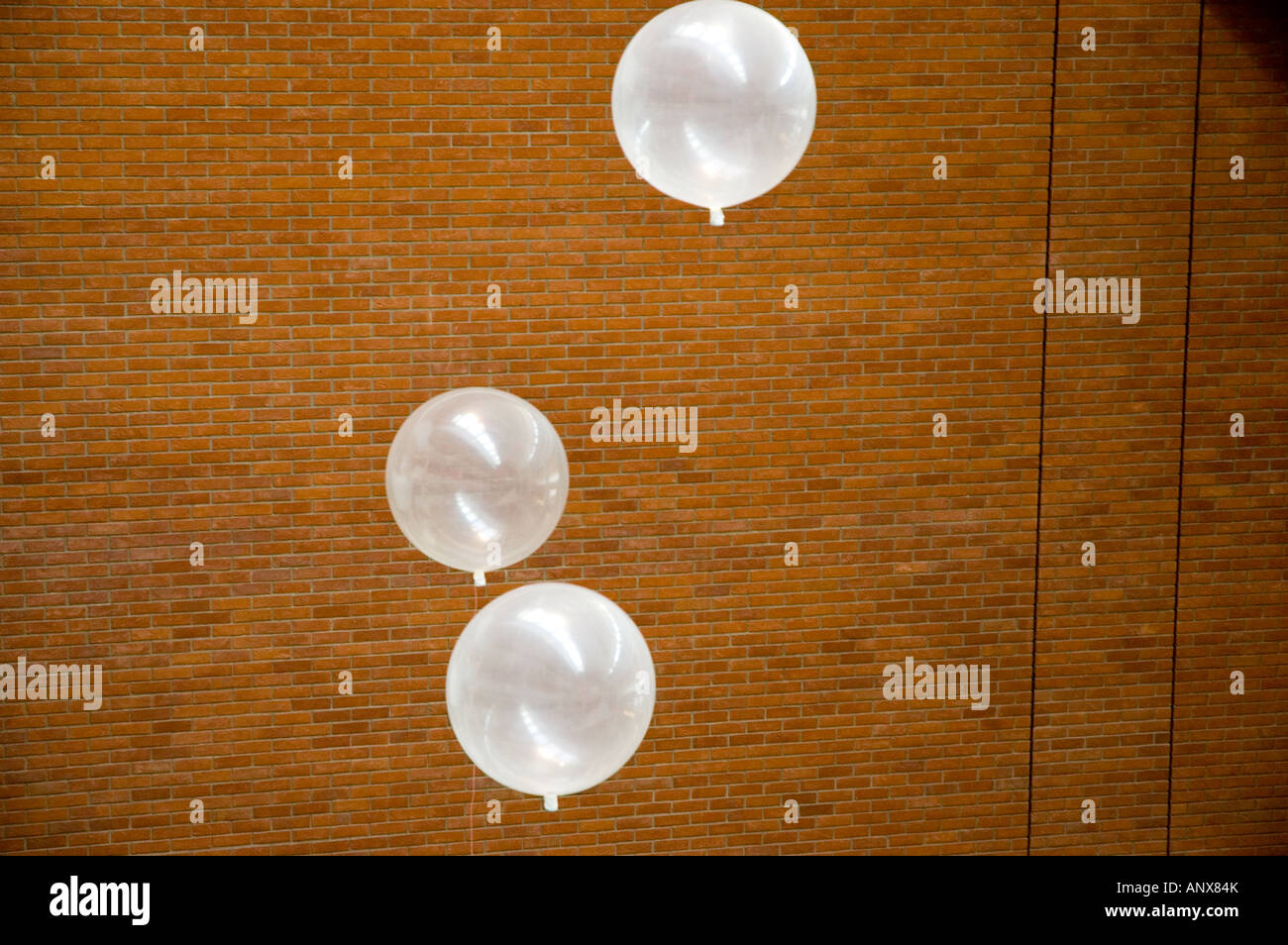 British Library three white balloon in a background of orange bricks ...