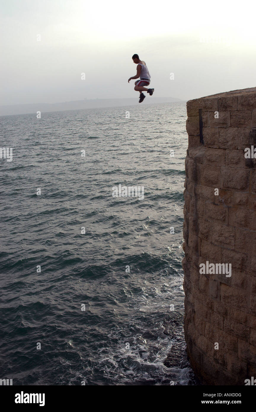 Boy jumping off wall into sea hi-res stock photography and images - Alamy