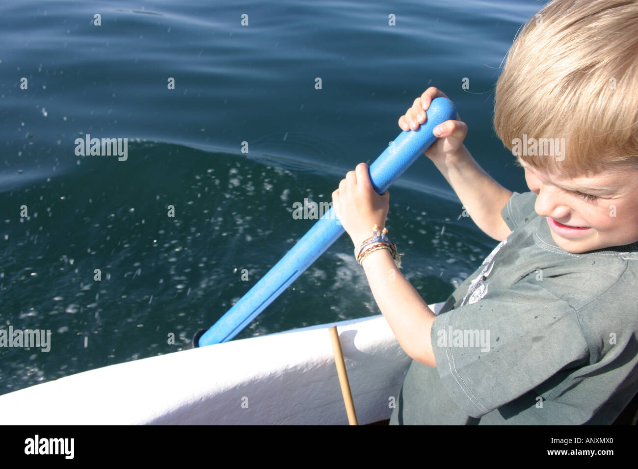 Boy rowing a boat Stock Photo - Alamy