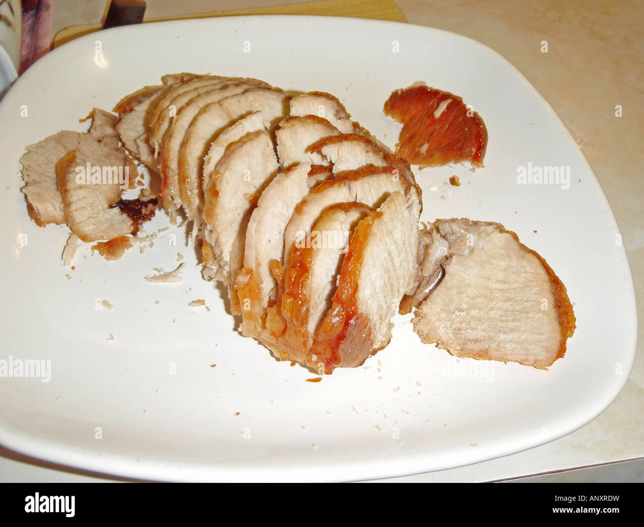Joint of pork loin sliced on a serving plate Stock Photo - Alamy