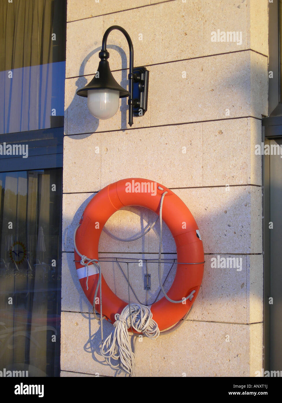 Light and life saving ring with rope on a hotel wall next to the ...