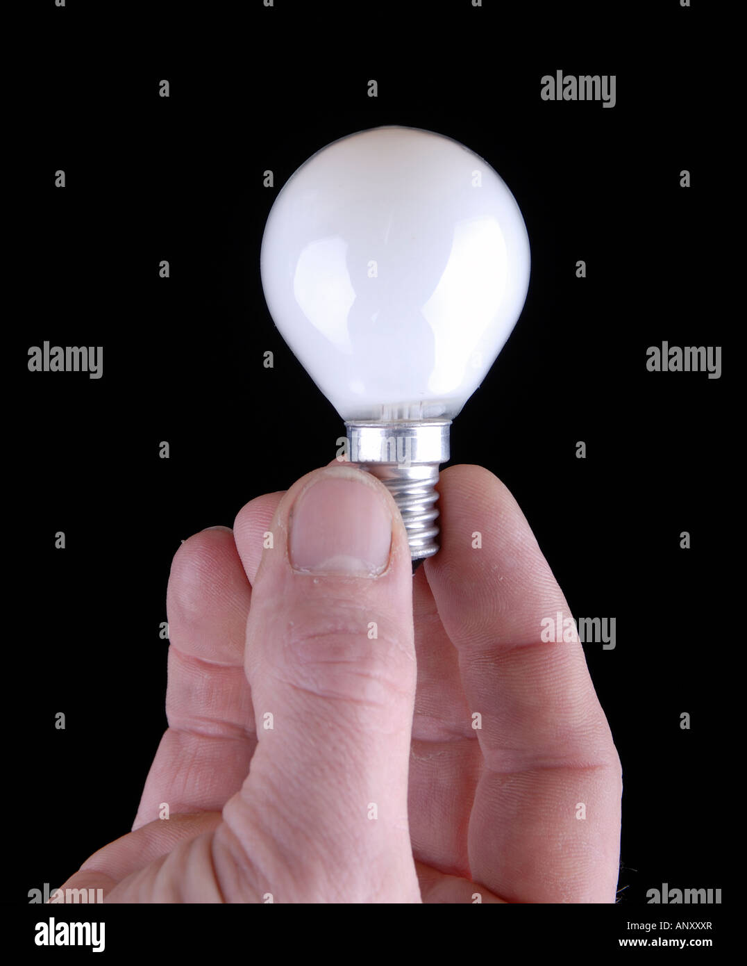 fingers holding a low energy light bulb Stock Photo - Alamy