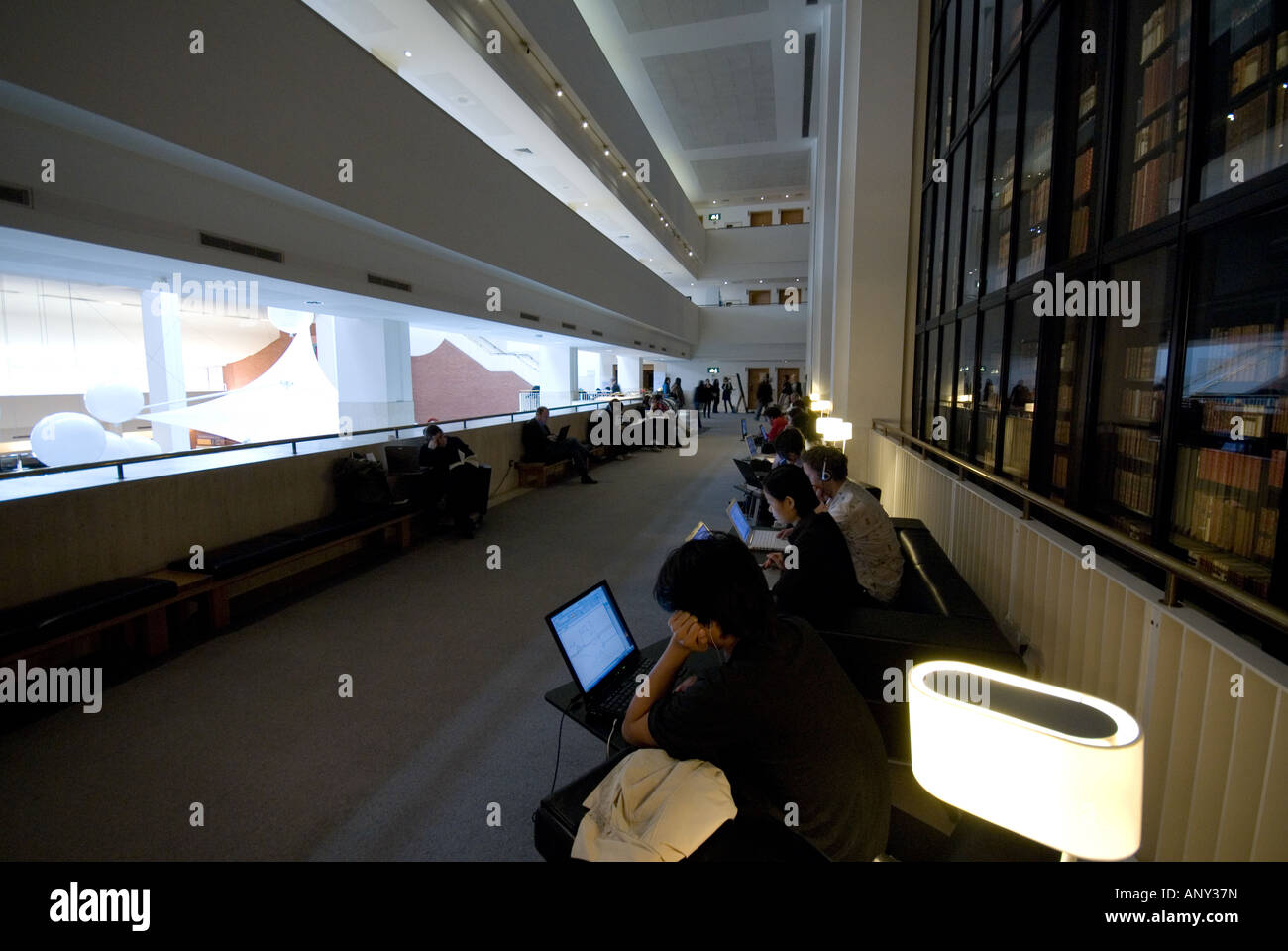 British Library inside people in line study or work with a laptop sit ...