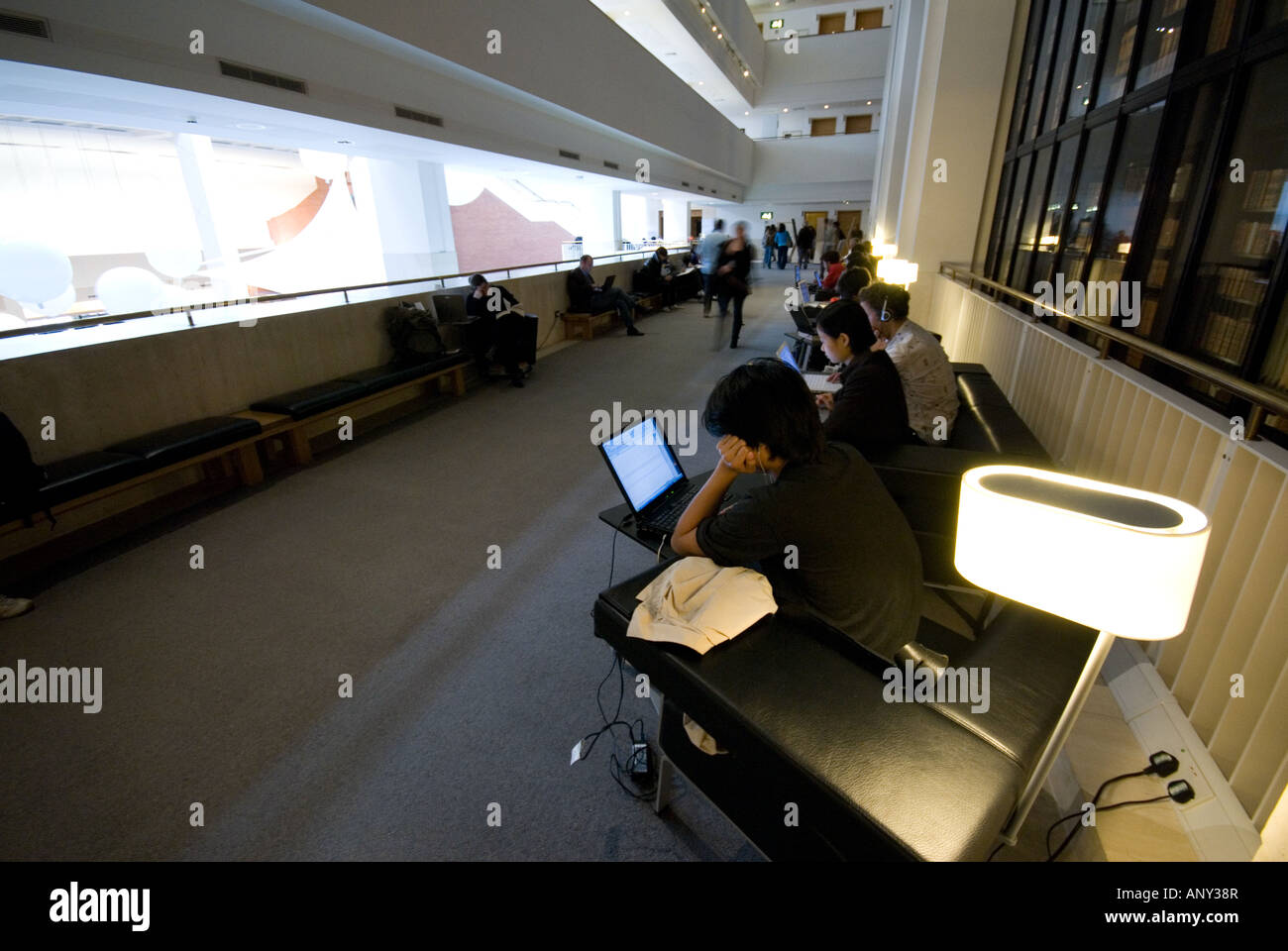 British Library inside people in line study or work with a laptop sit ...