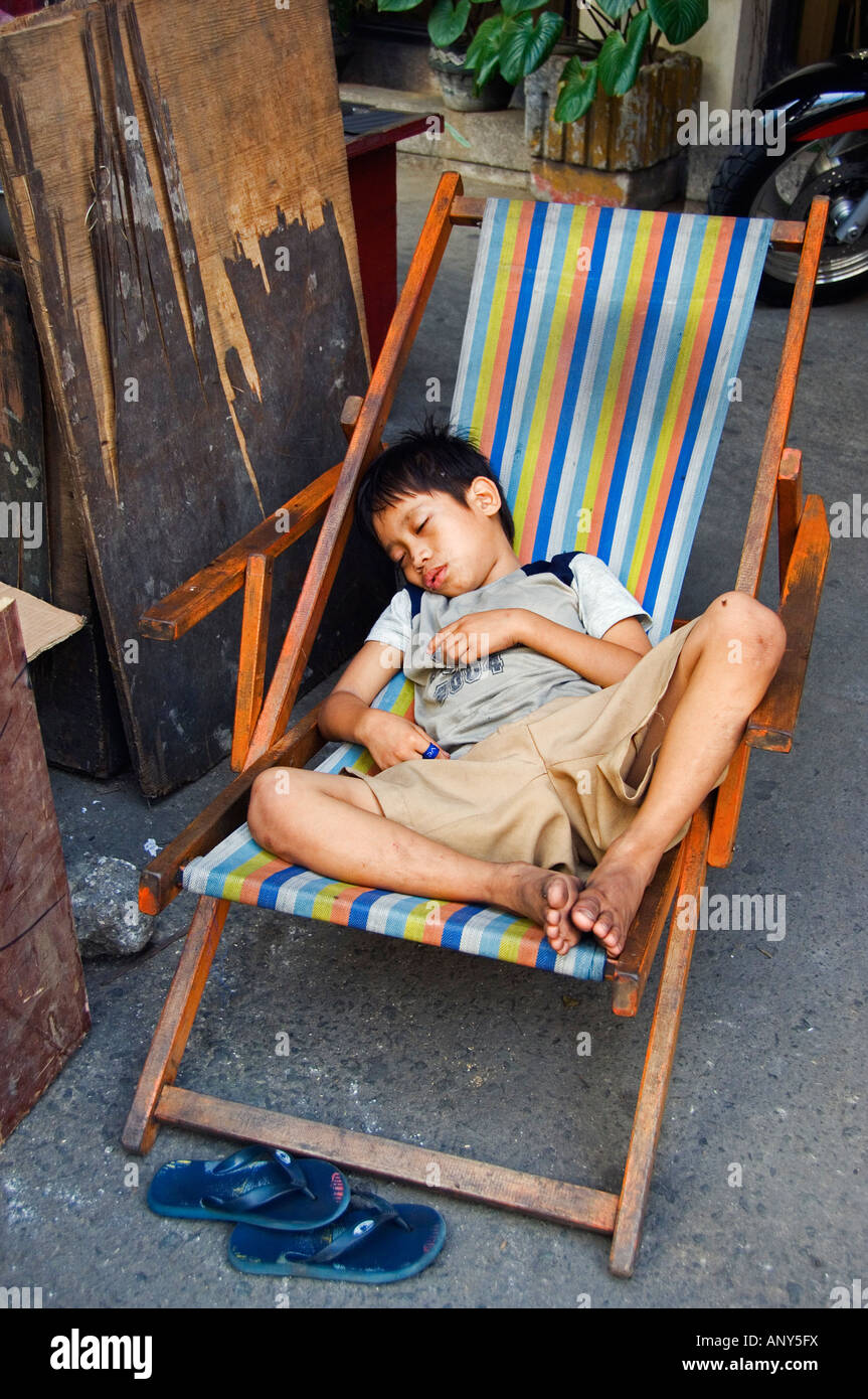 Philippines, Luzon, Manila. Boy sleeping on deck chair Stock Photo - Alamy