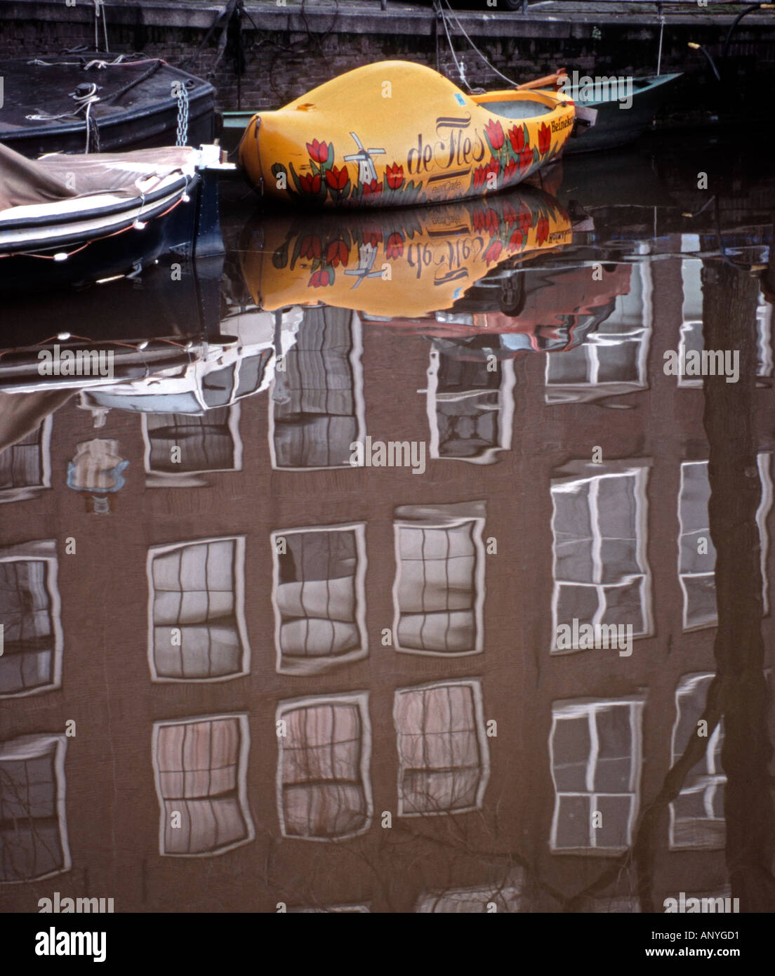 Yellow clog-shaped boat decorated with tulips on canal in Amsterdam ...