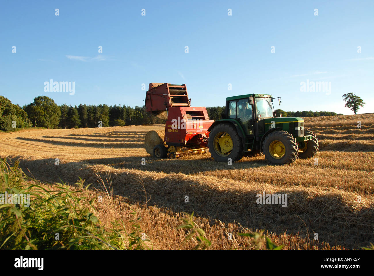 Tractor towing bailing machine in field Farming in Derbyshire Britain ...