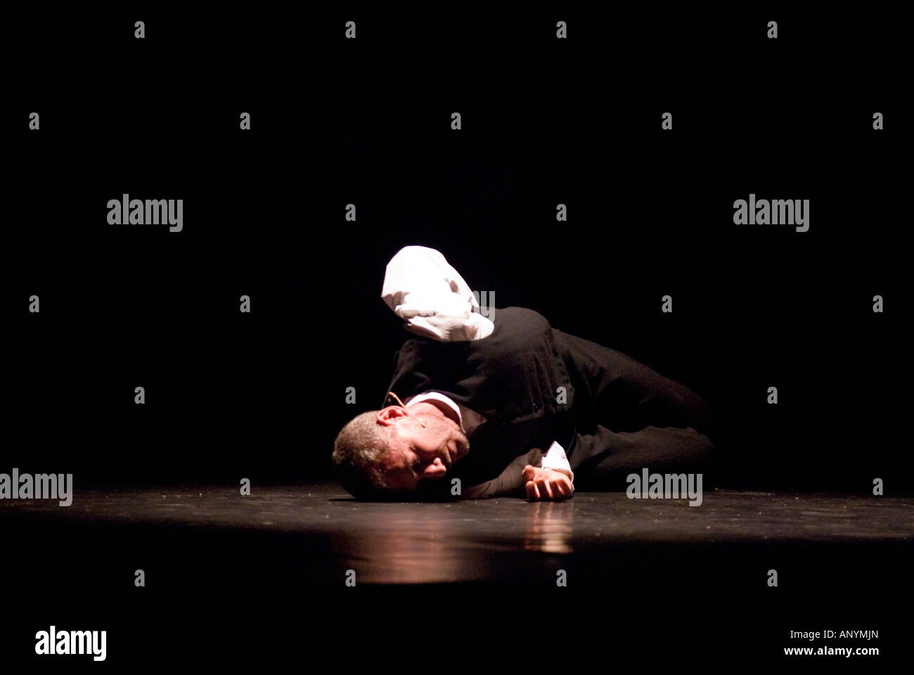 a man in the sideway down on the floor in a black background Stock ...