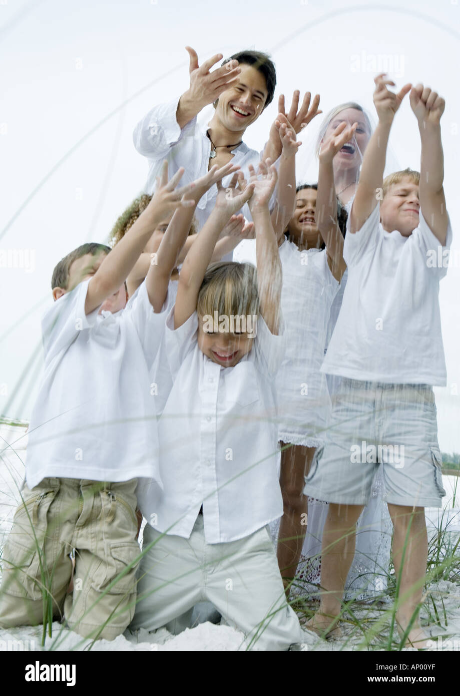 Beach wedding, children and groom throwing rice in air Stock Photo - Alamy
