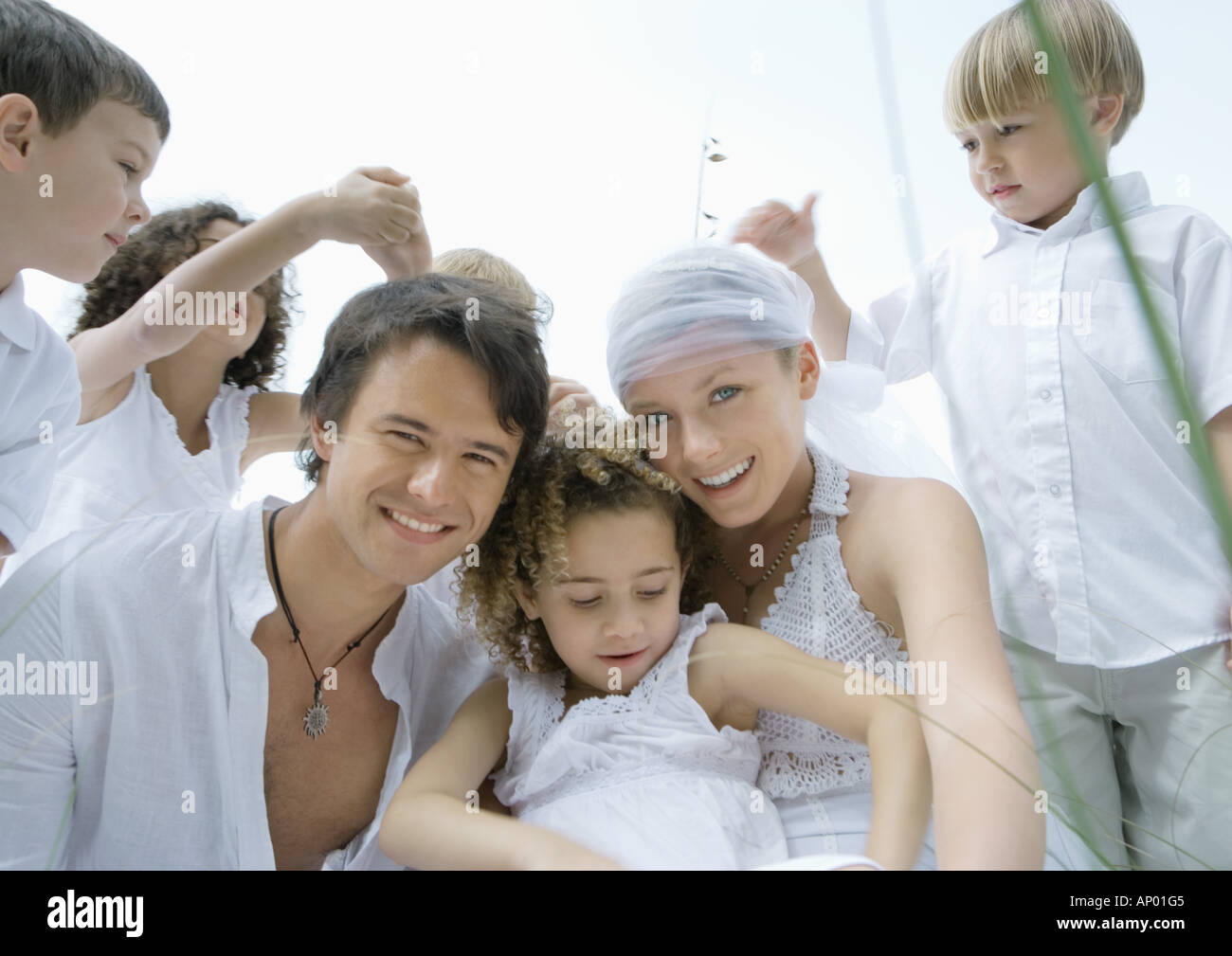 Young married couple surrounded by children Stock Photo - Alamy