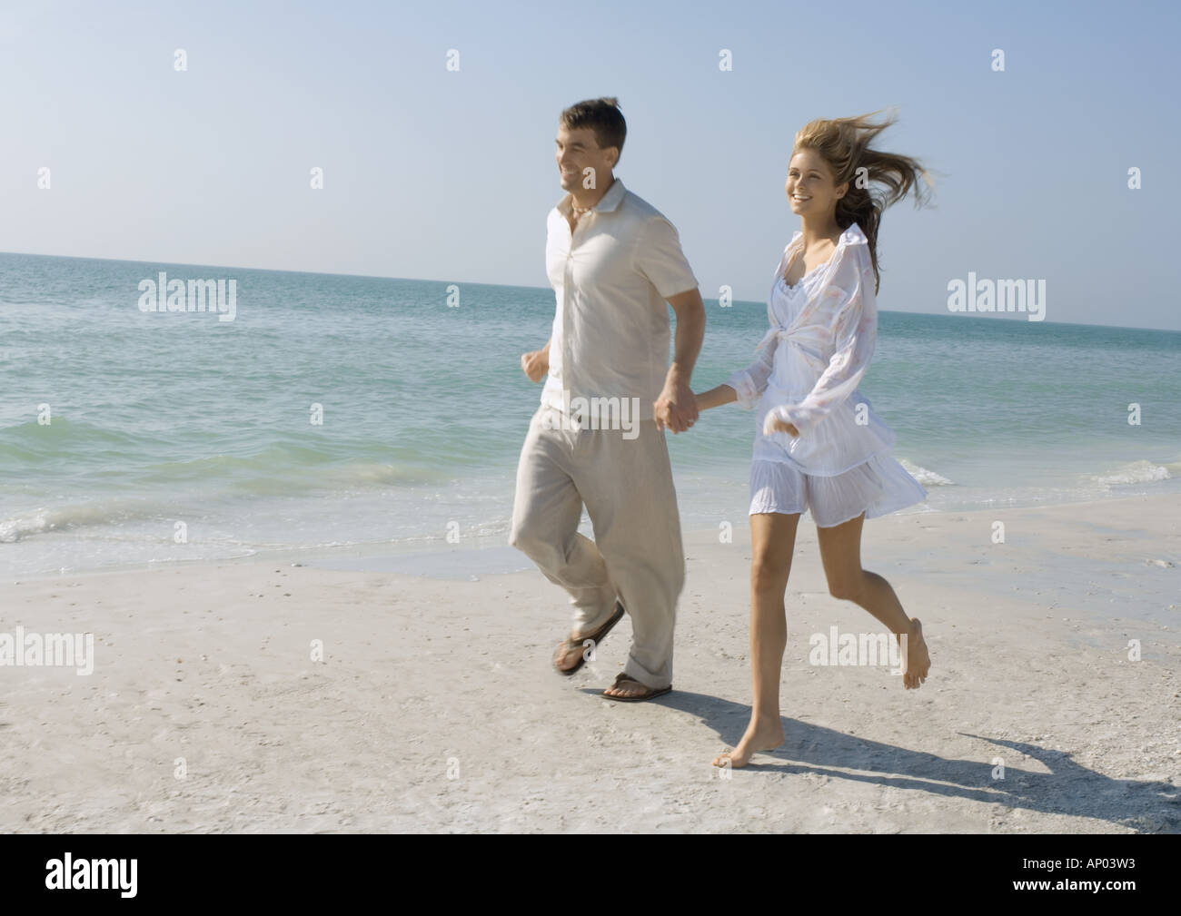 Couple running on beach Stock Photo - Alamy