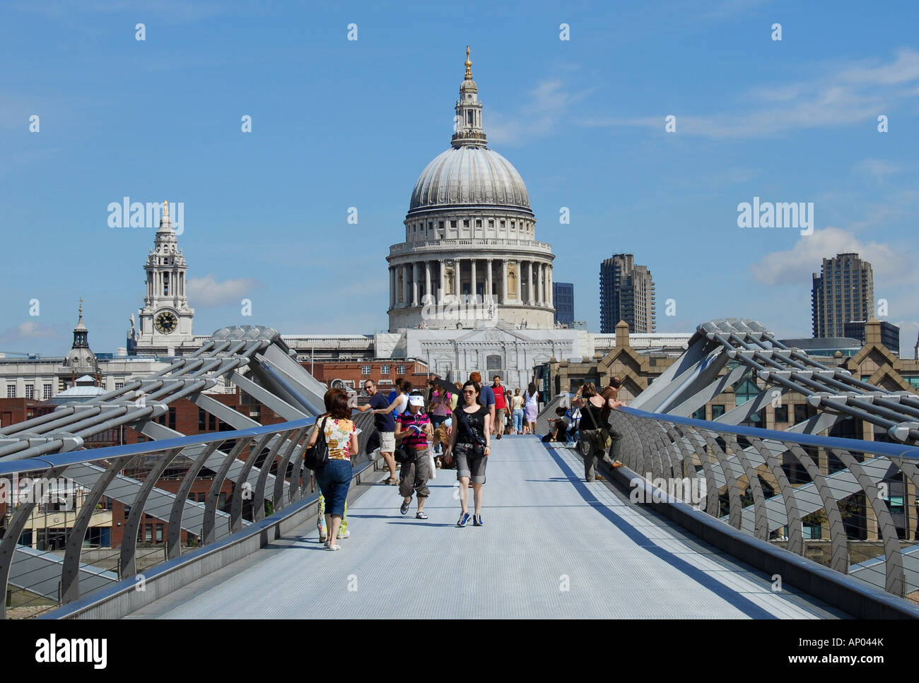 Pedestrians walking across the Millenium bridge in London with St Paul ...
