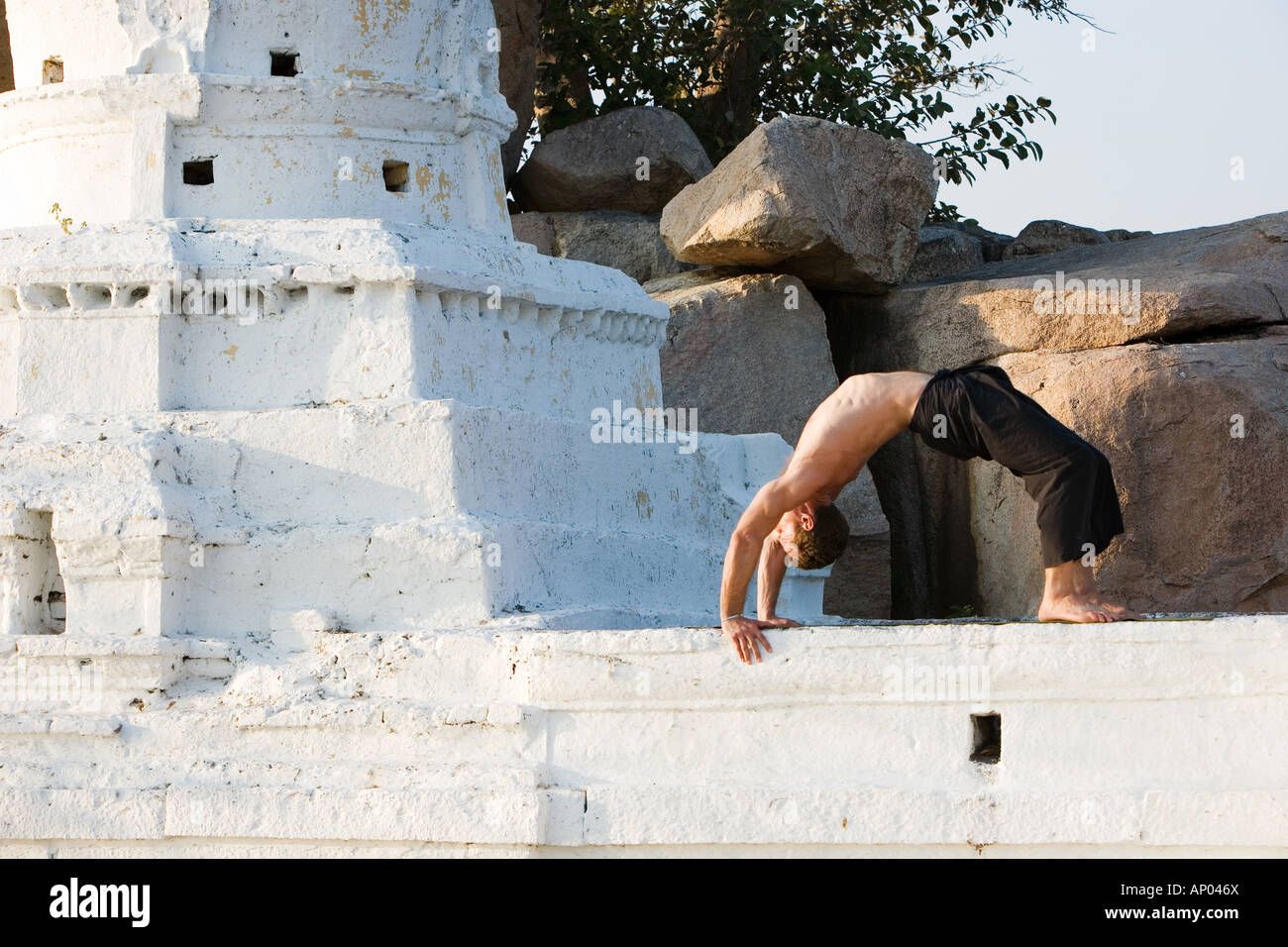 Man performing Hatha Yoga, Urdhva Dhanurasana, wheel posture on a hindu ...