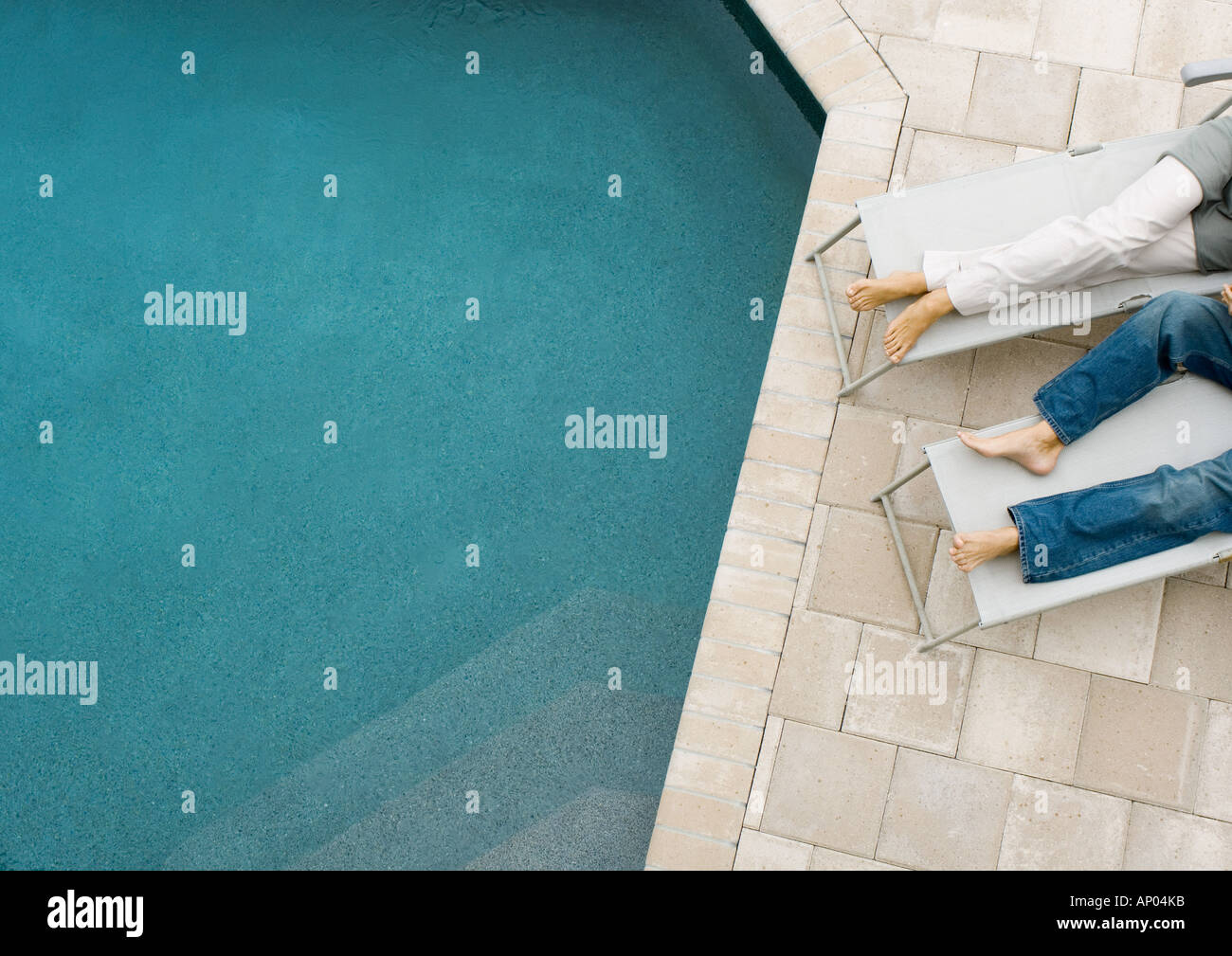 Couple lounging by pool, cropped Stock Photo - Alamy