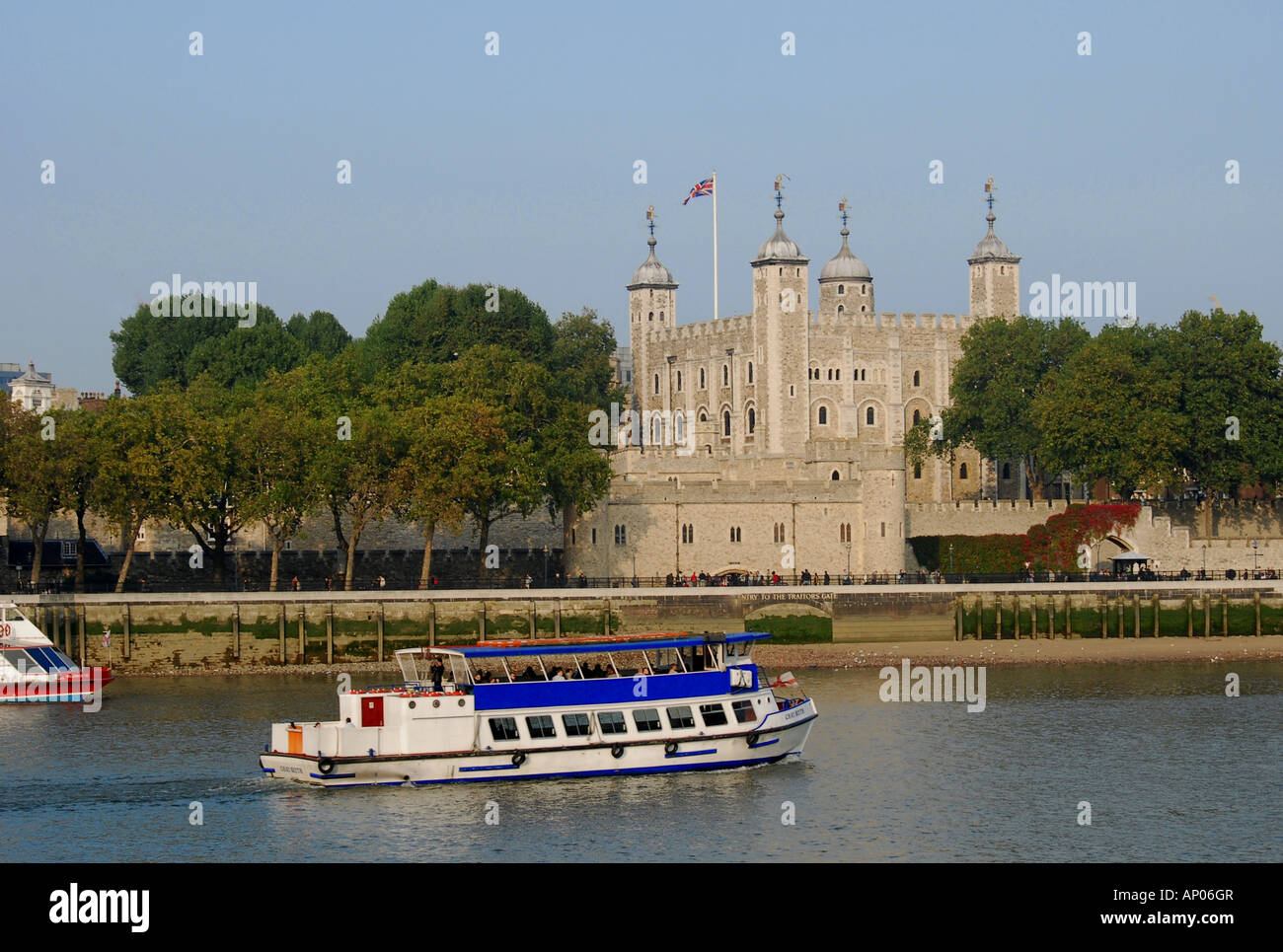 A sightseeing boat on the river Thames passes the tower of London Stock ...