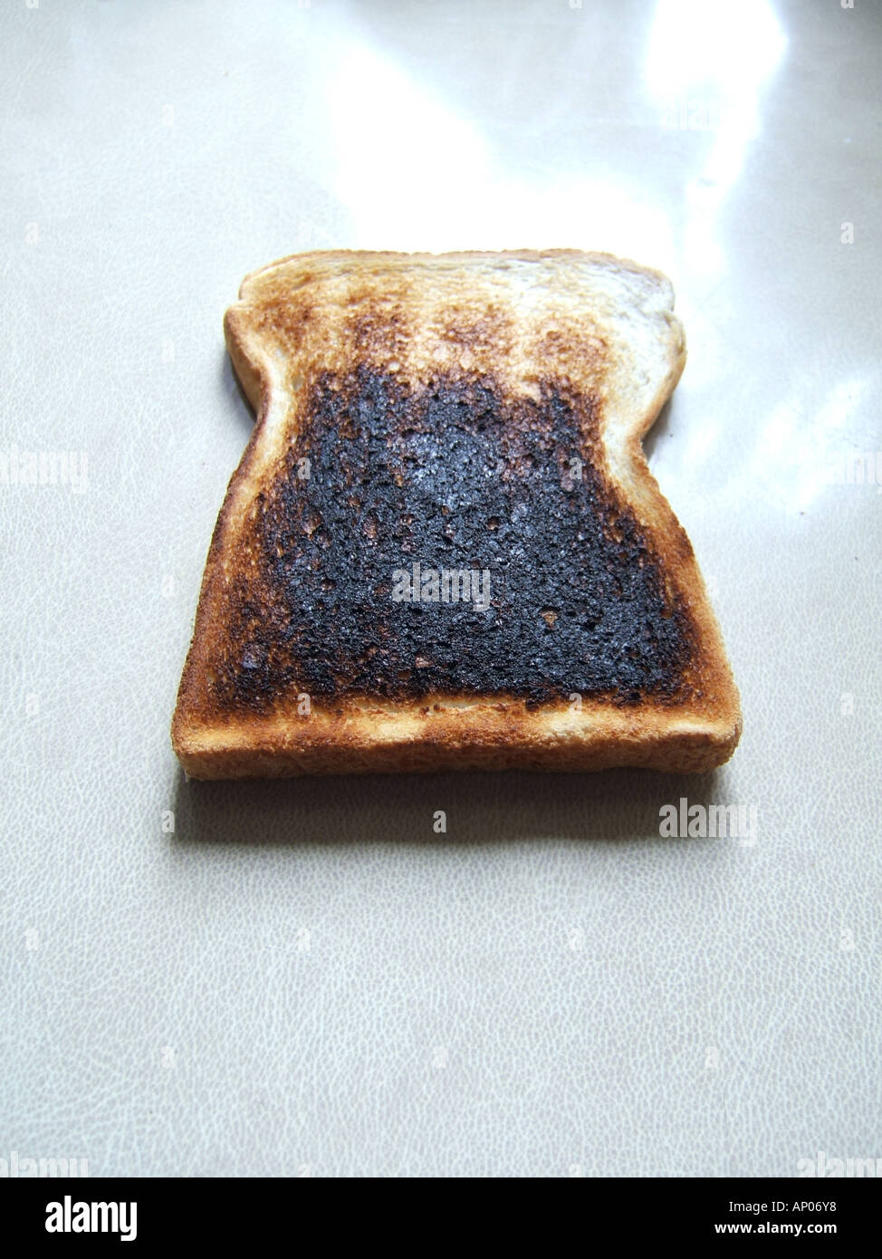one slice of burnt toast on kitchen work top Stock Photo - Alamy