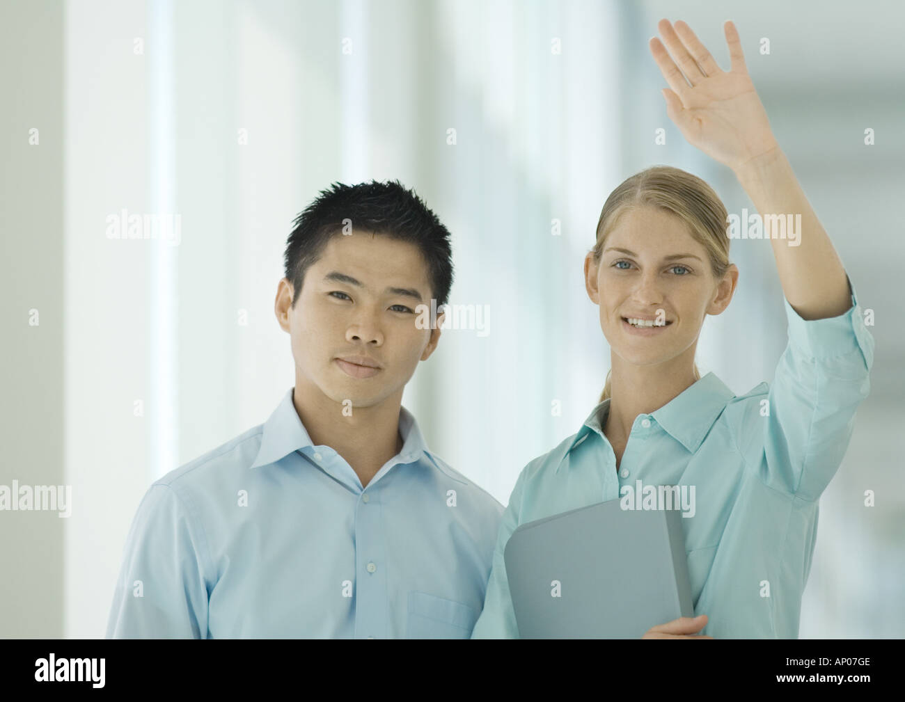 Two office workers, one waving Stock Photo - Alamy