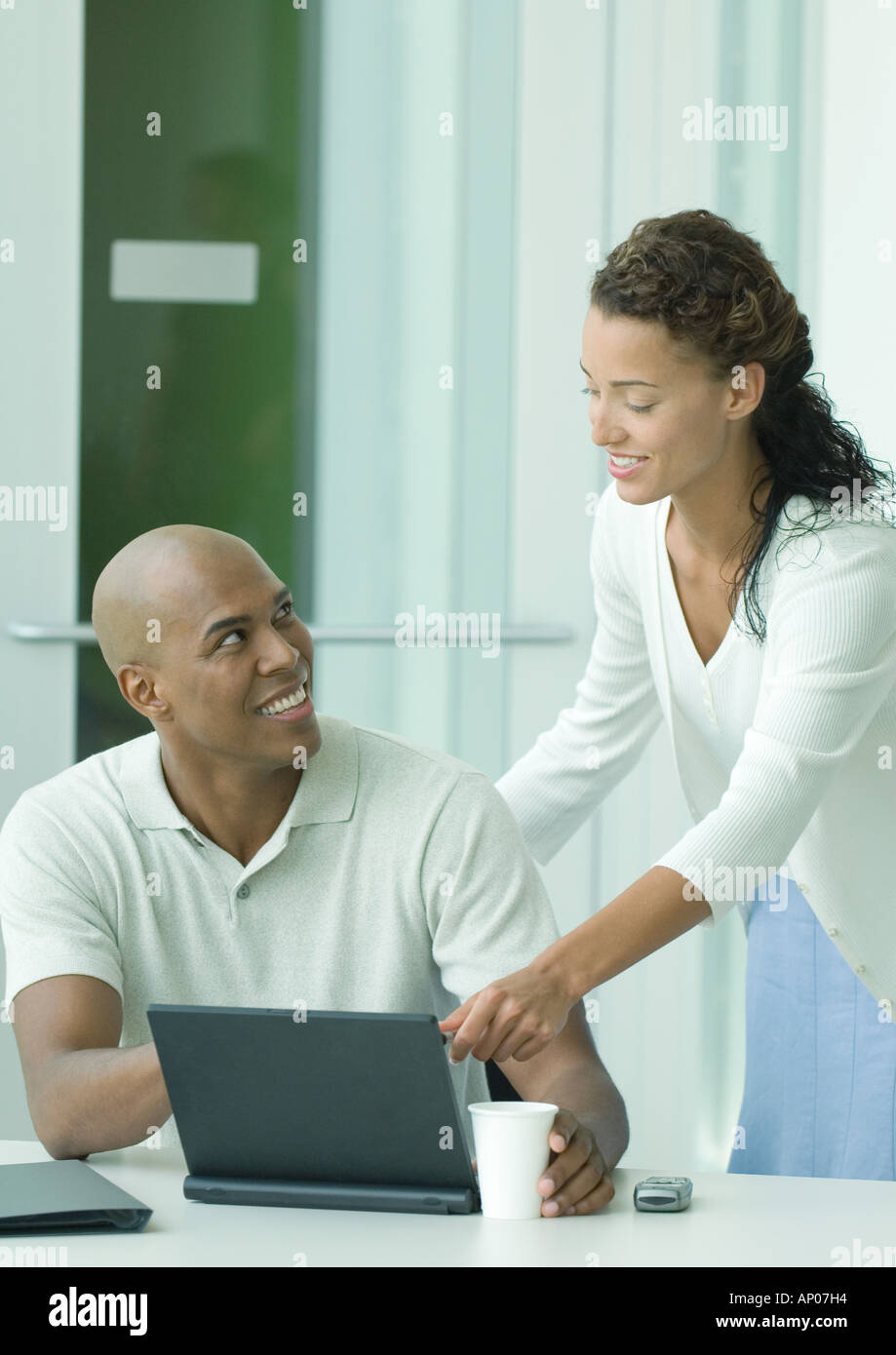 Woman helping male colleague Stock Photo - Alamy