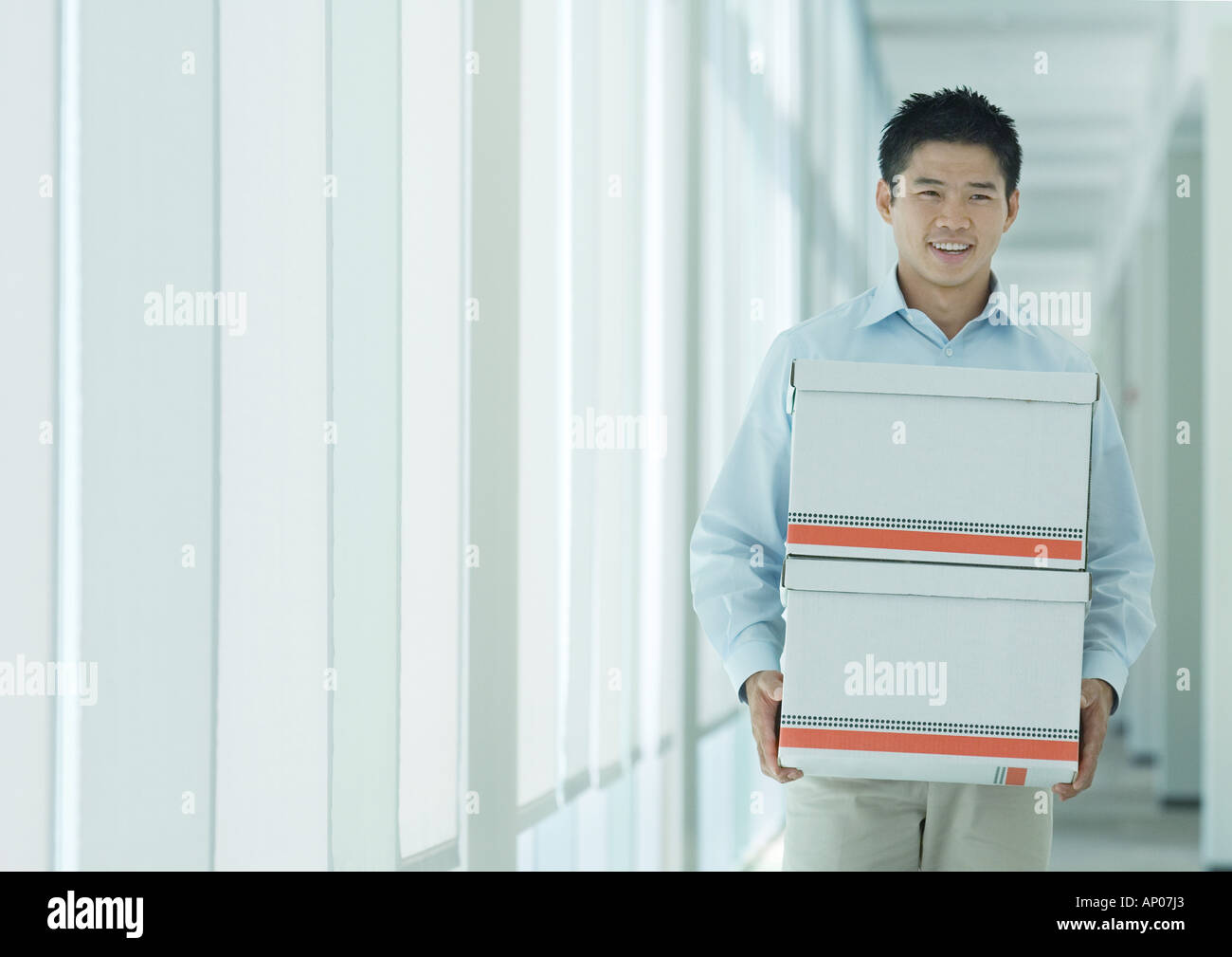 Man carrying boxes in hallway Stock Photo - Alamy