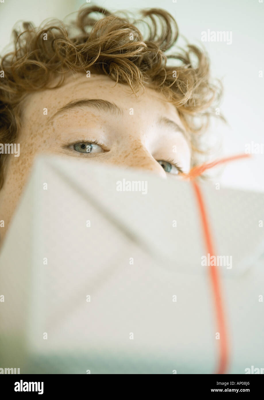 Boy looking over edge of present Stock Photo - Alamy