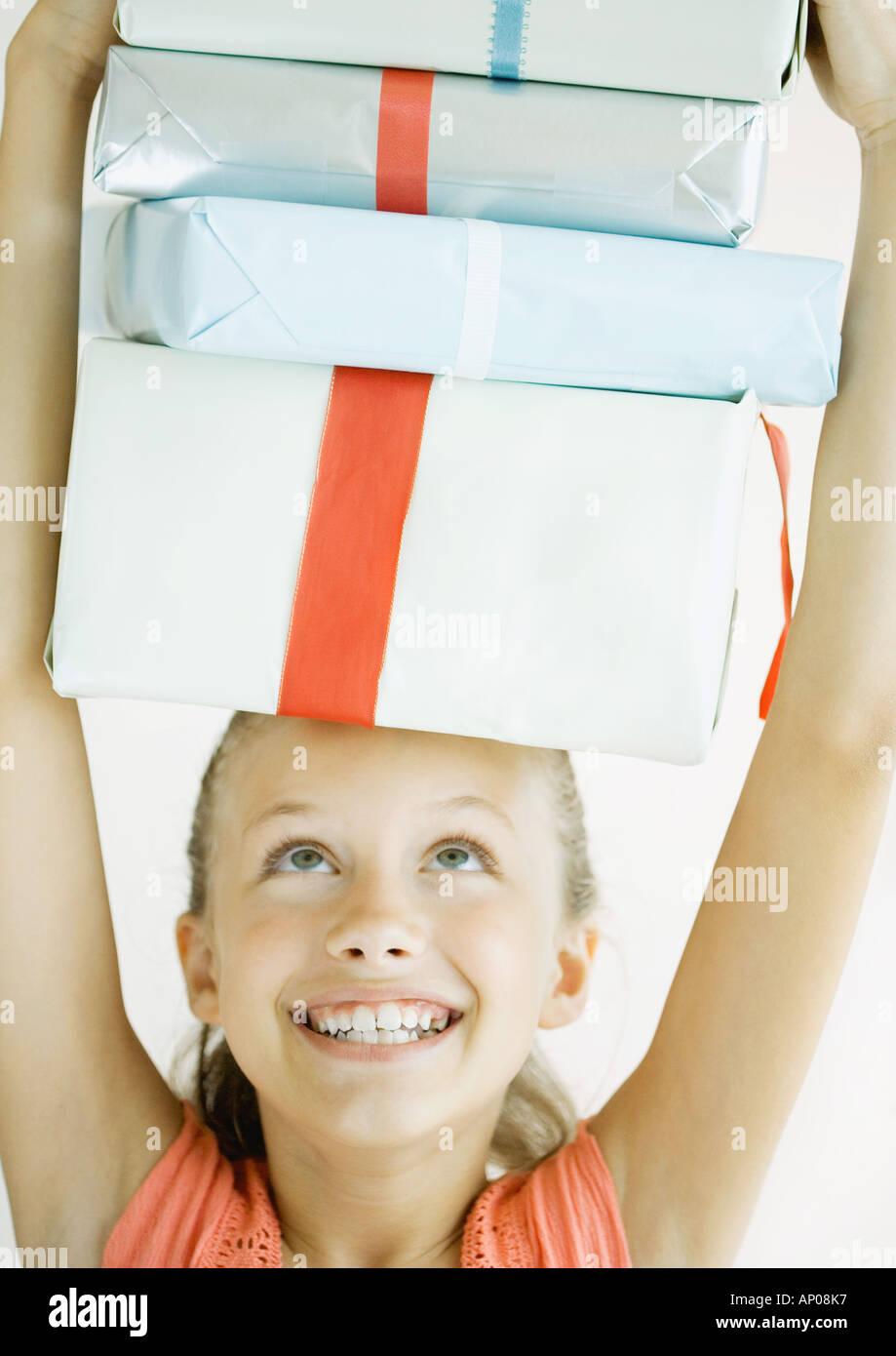 Girl holding stack of presents on head Stock Photo - Alamy