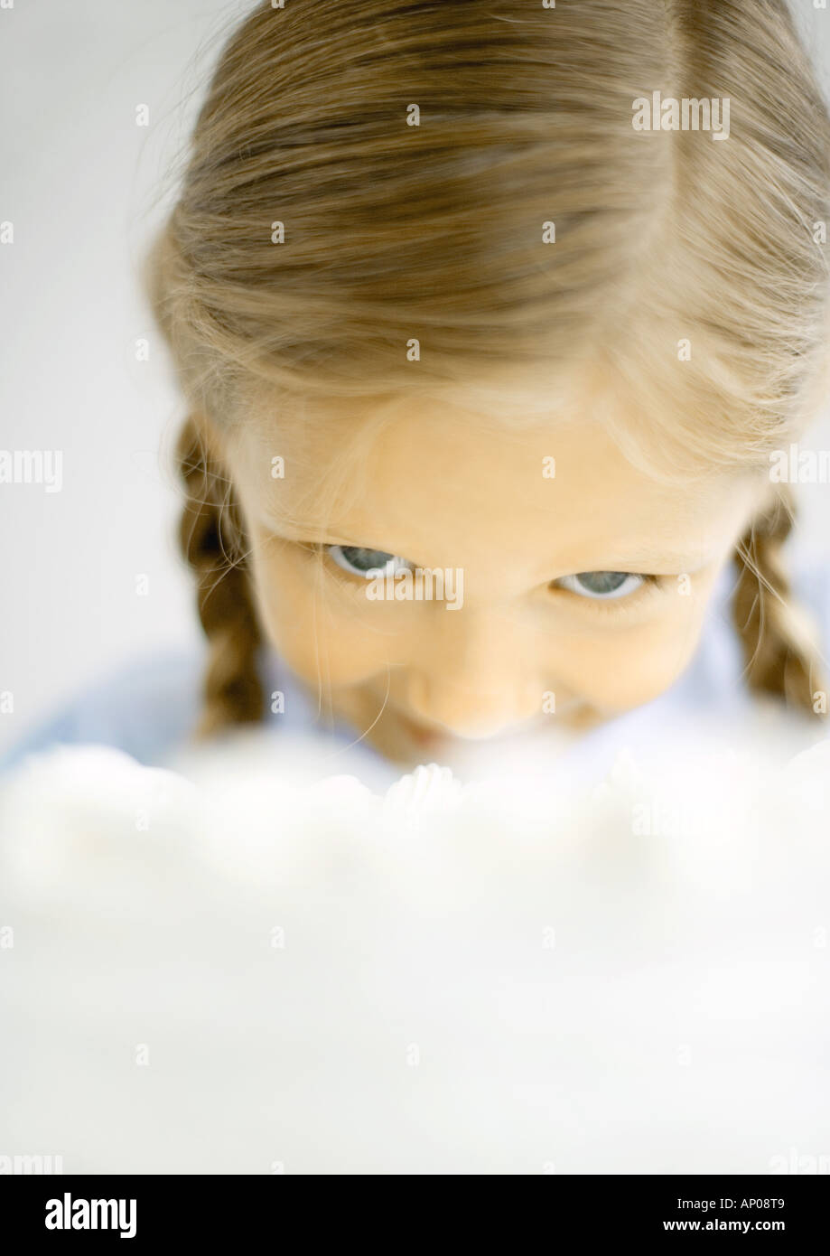 Girl lowering head to eat cake Stock Photo - Alamy