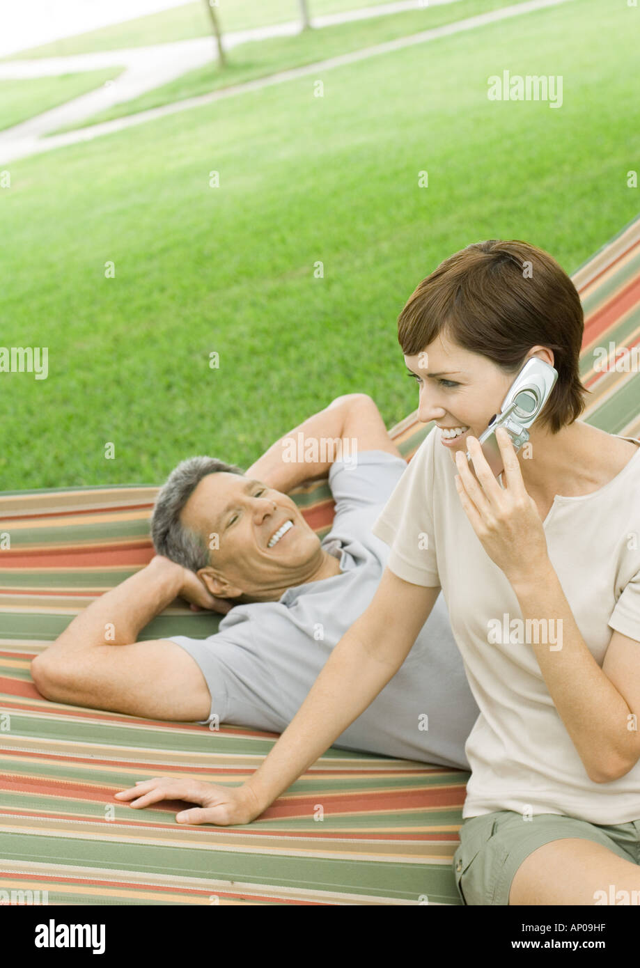 Mature couple lounging in hammock, woman using cell phone Stock Photo ...