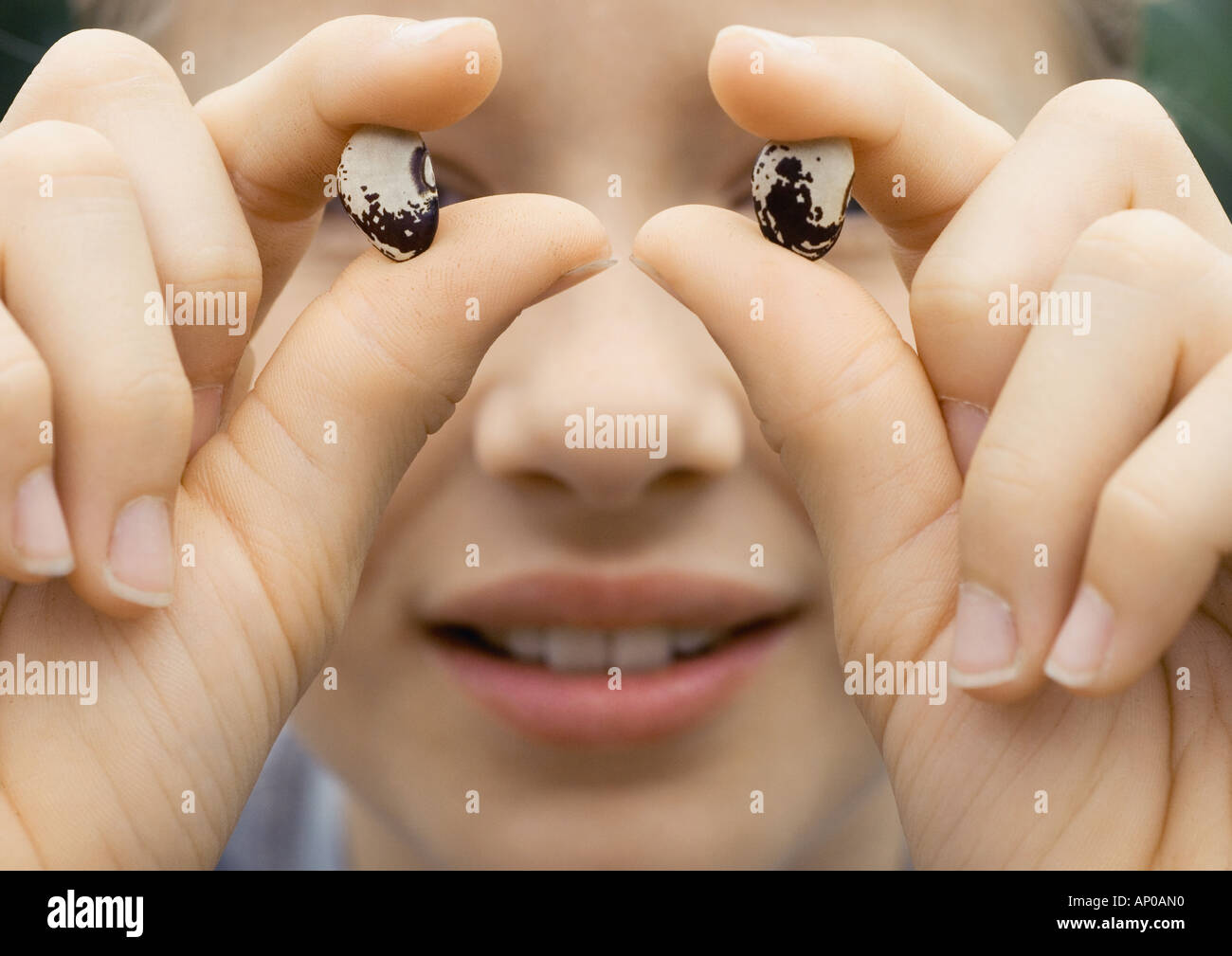 Child holding up seeds in front of eyes Stock Photo - Alamy