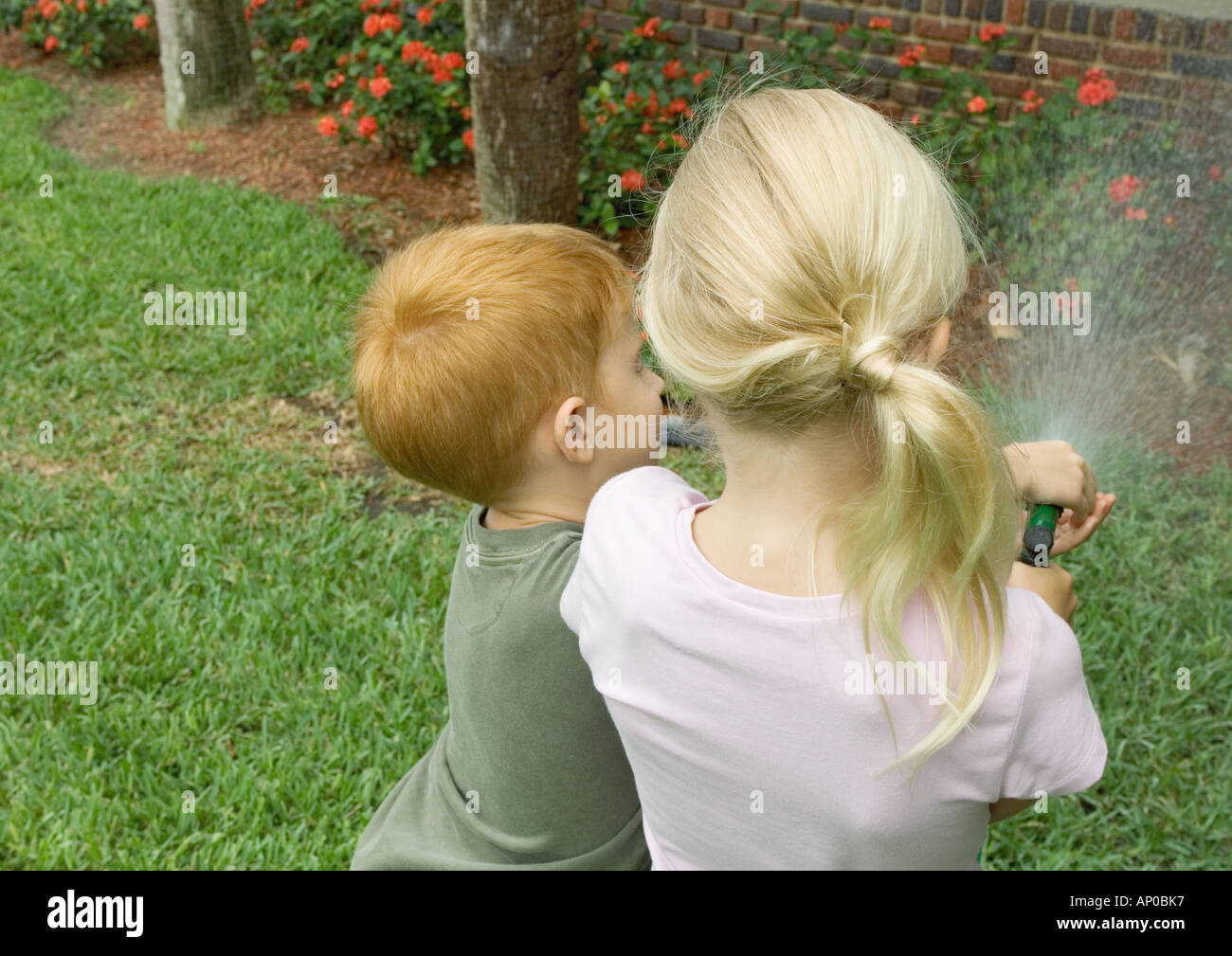 Girl spraying boy hose hi-res stock photography and images - Alamy