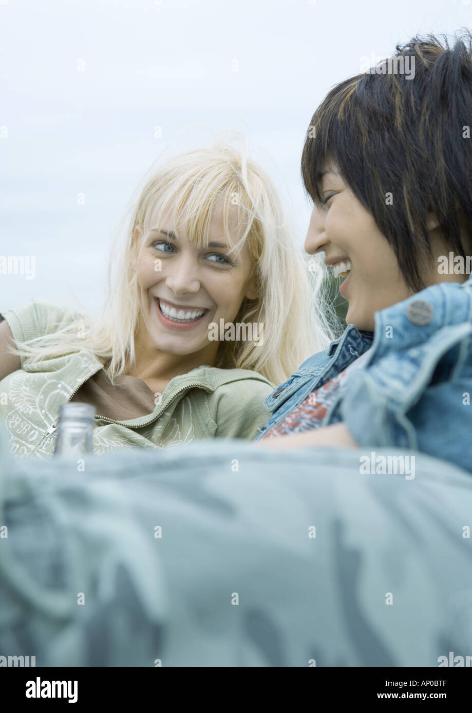 Two young women reclining and laughing Stock Photo - Alamy