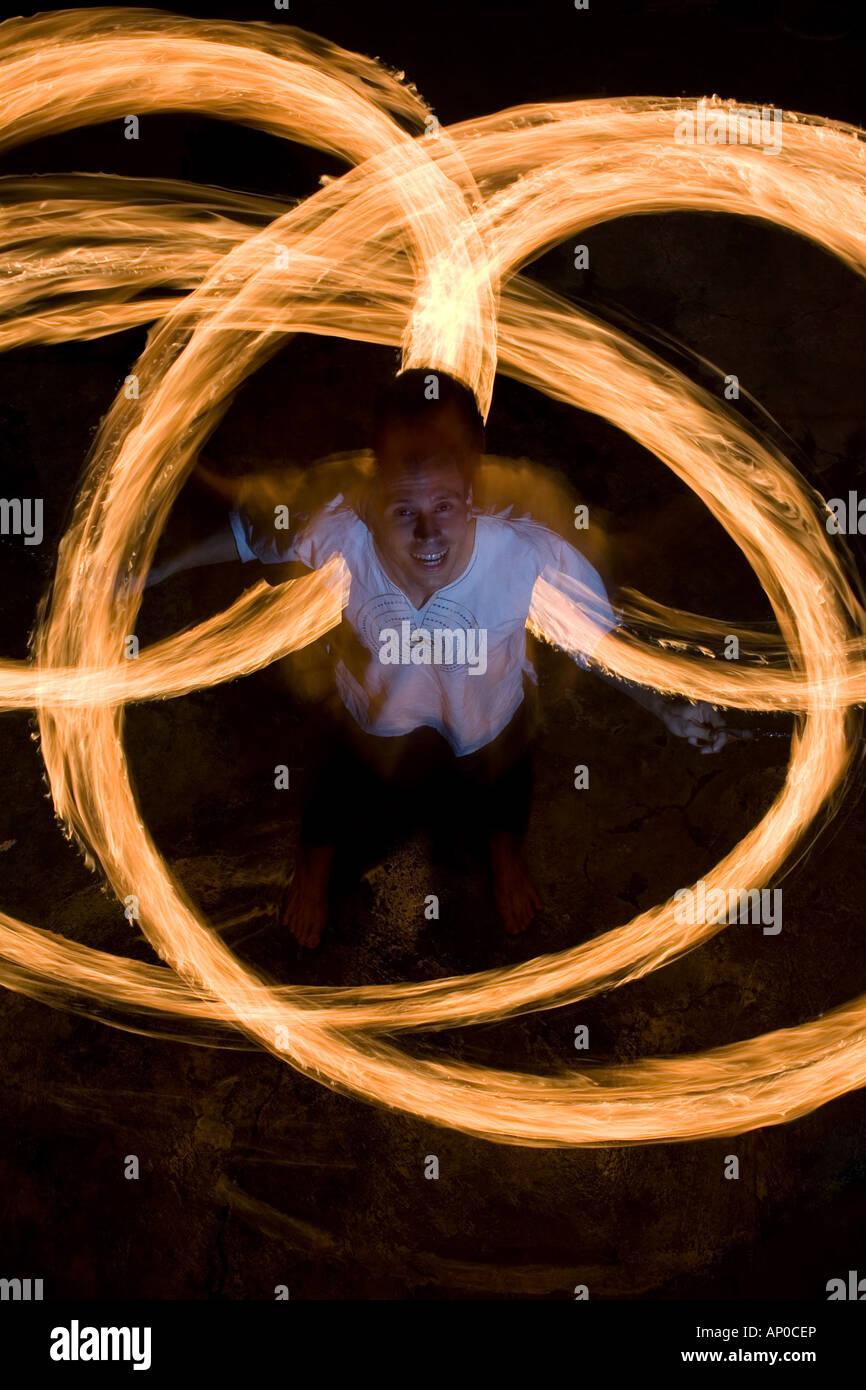 Man Fire dancing with fire sticks at night. India. Abstract Pattern ...