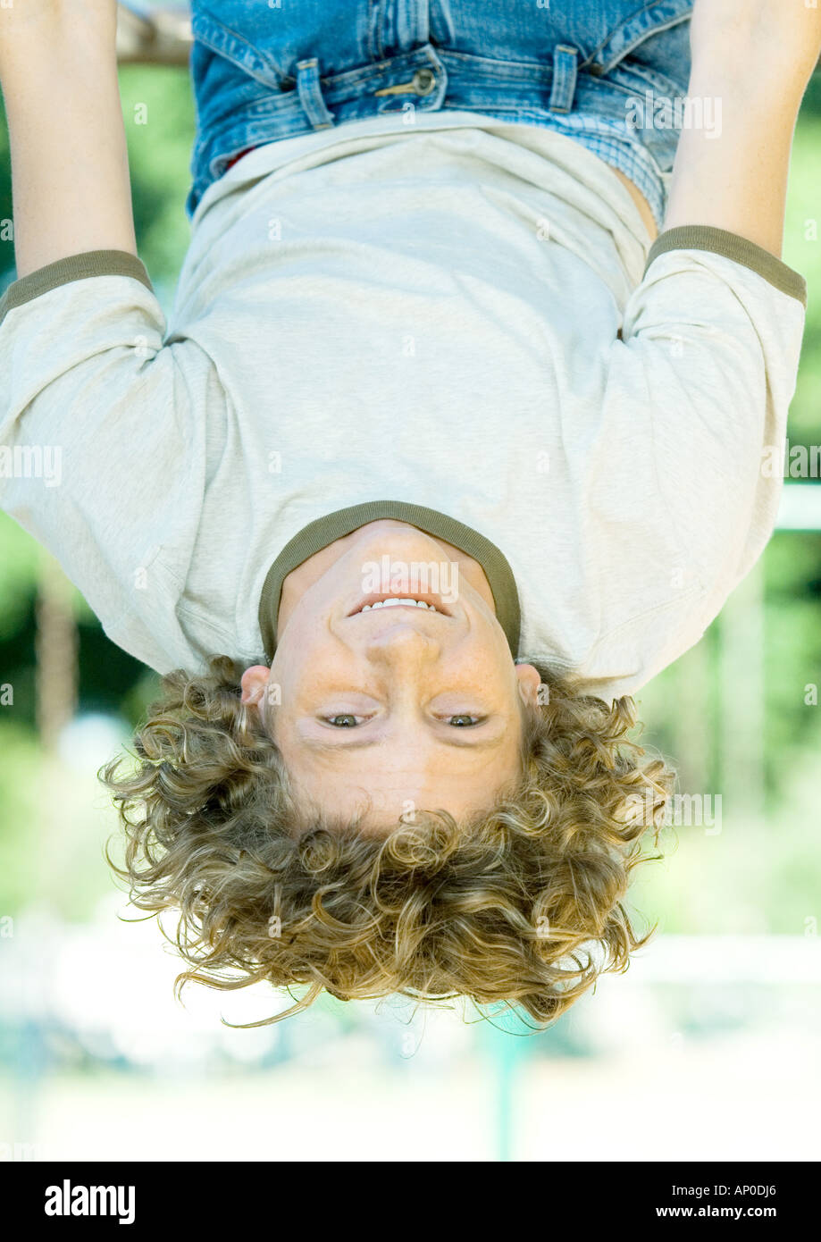 Teenage boy hanging upside down Stock Photo - Alamy